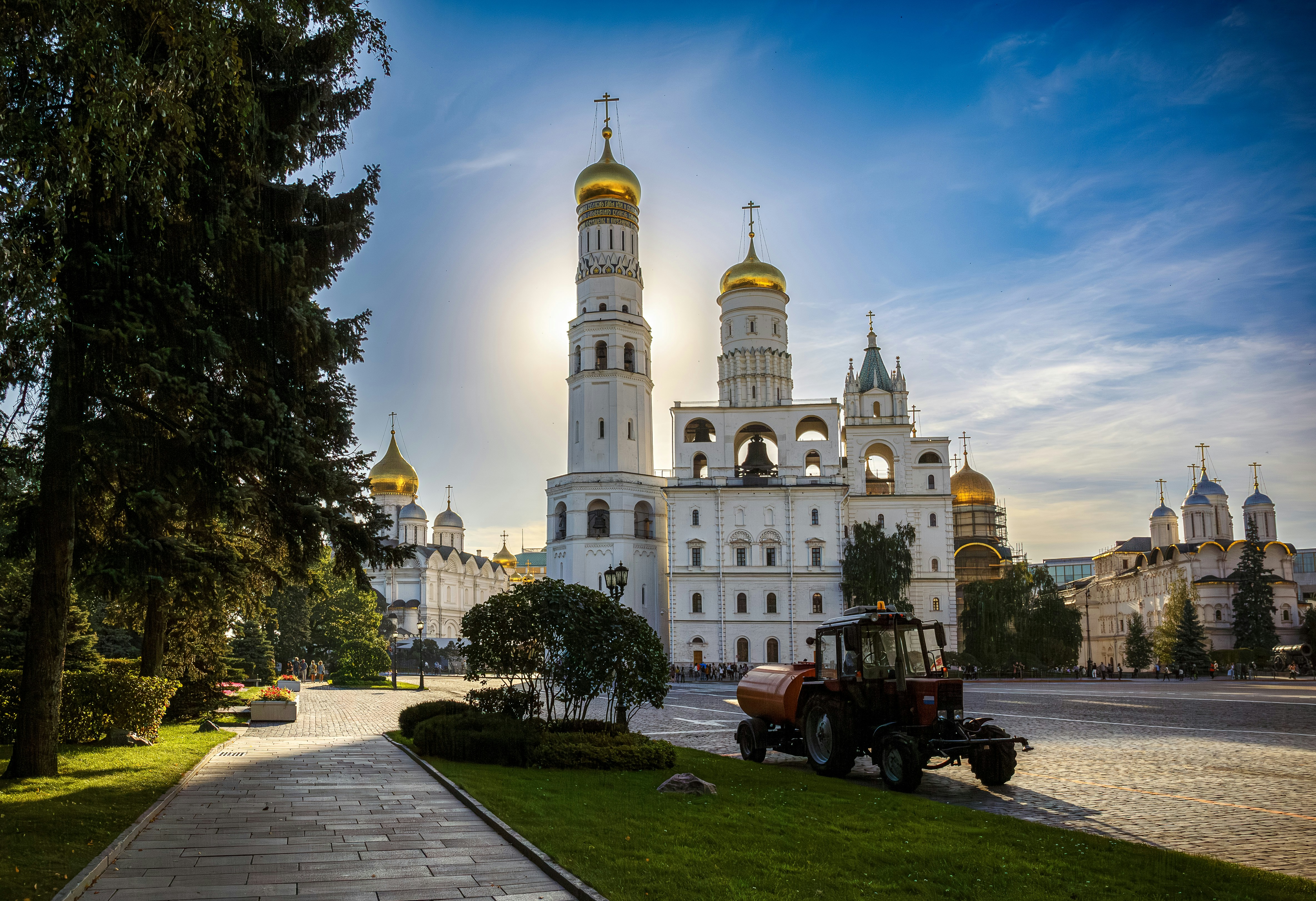 Sunlit Cathedral Courtyard: Golden Domes Framed by a Tractor in the Square
