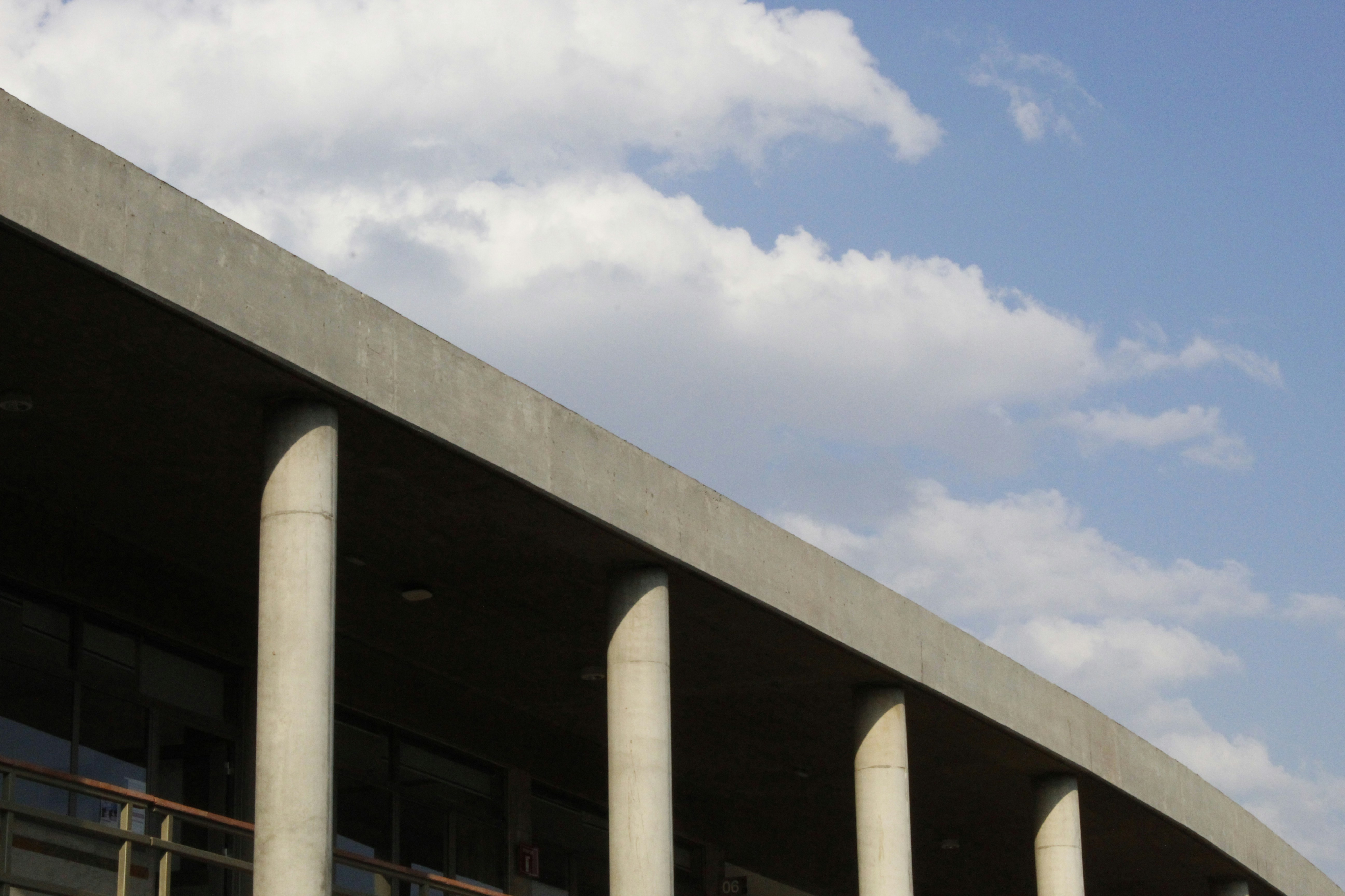 An airplane is flying in the sky over a building photo – Free Sky Image ...