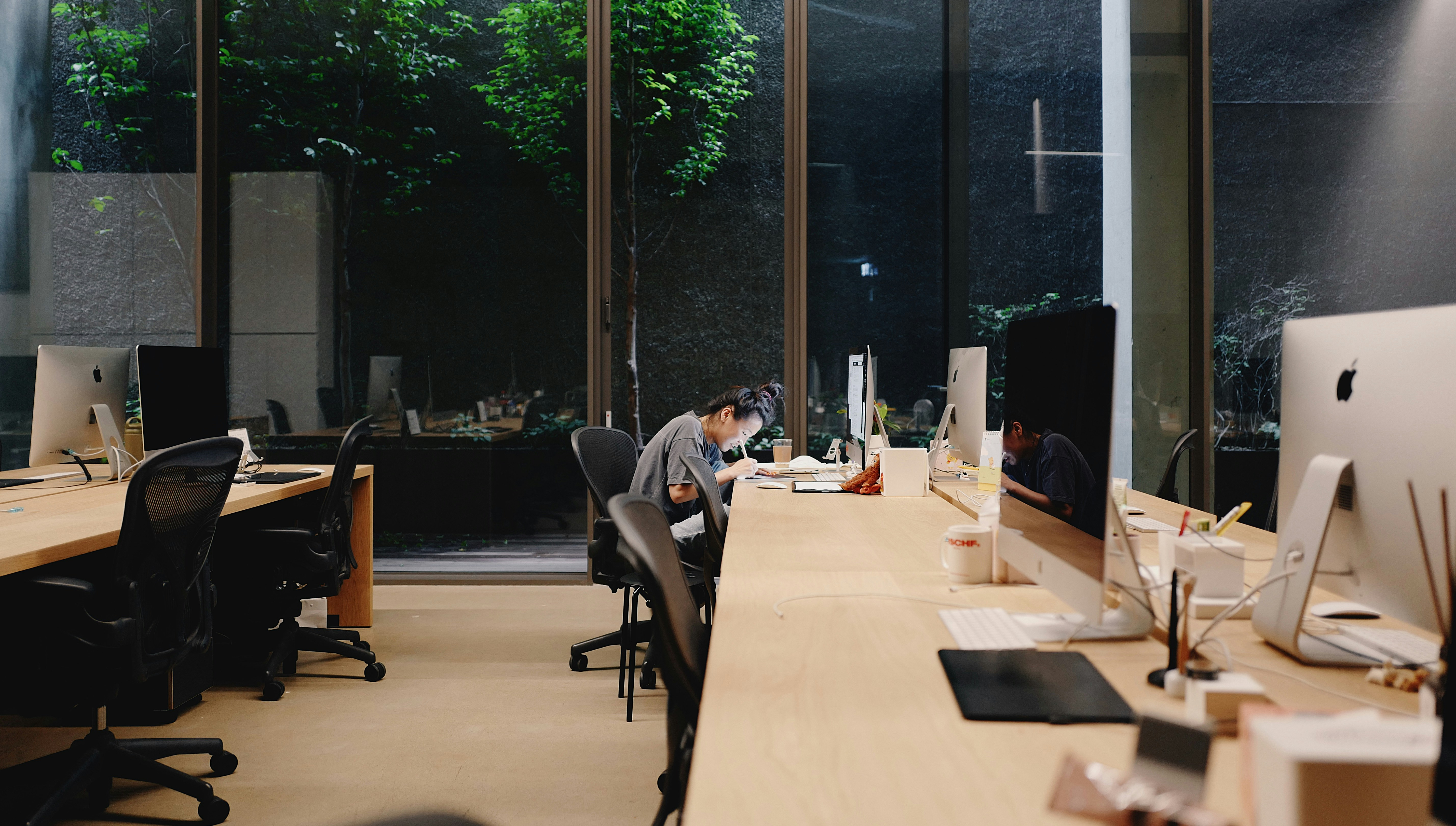 A man sitting at a desk working on a computer photo – Free Office Image ...