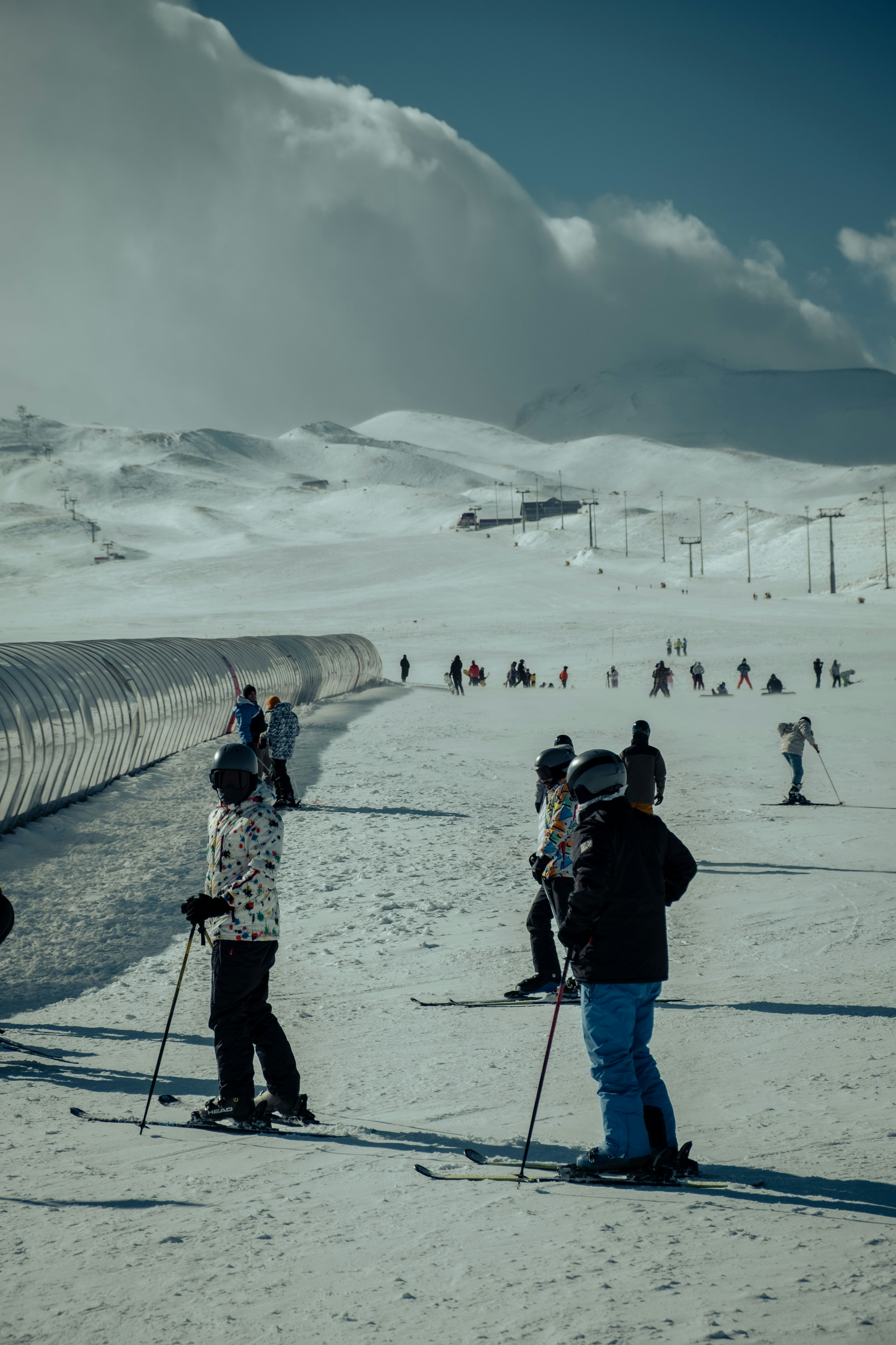 A group of people riding skis on top of a snow covered slope photo ...