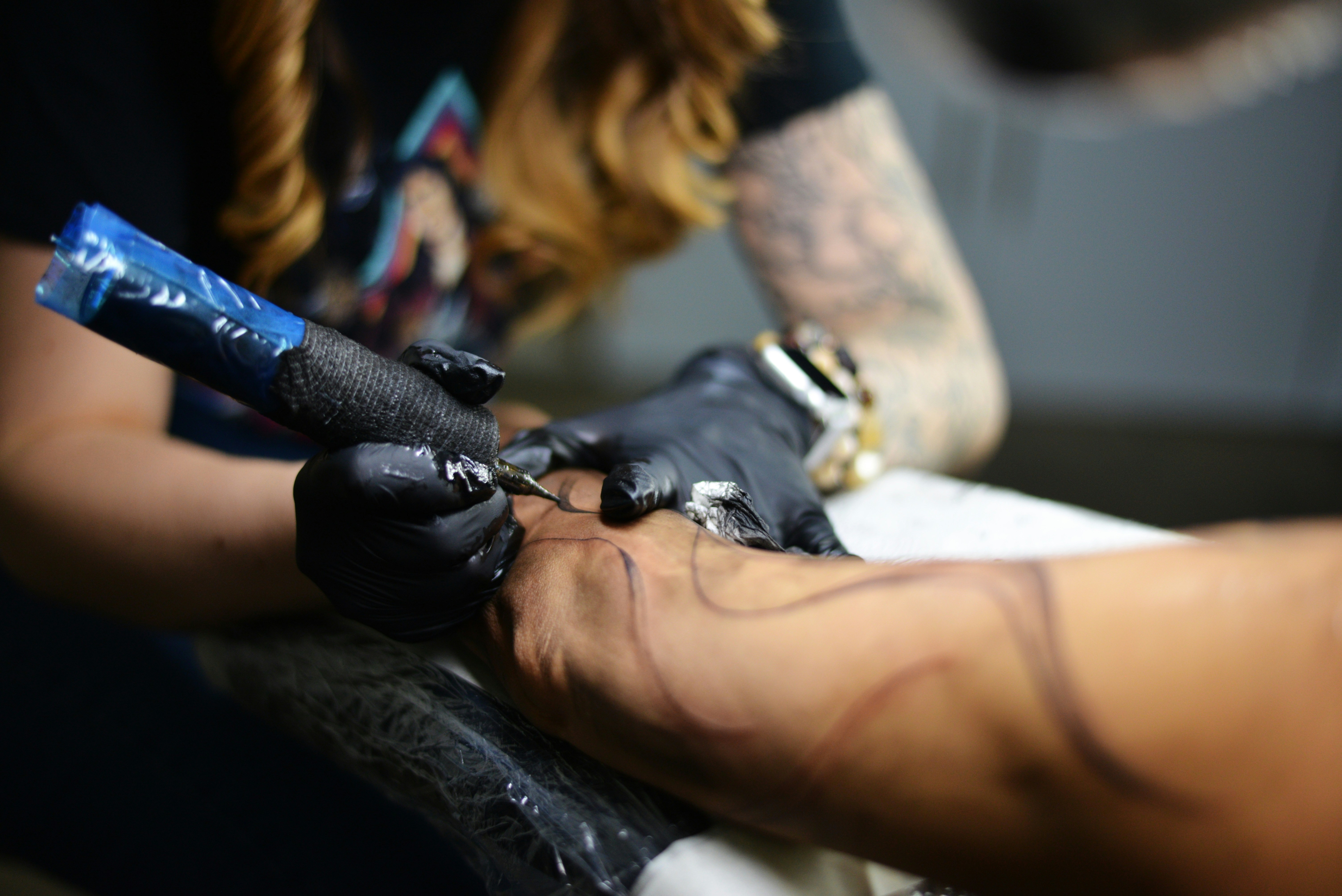 A person getting a tattoo on another person's arm photo – Free Ukraine ...