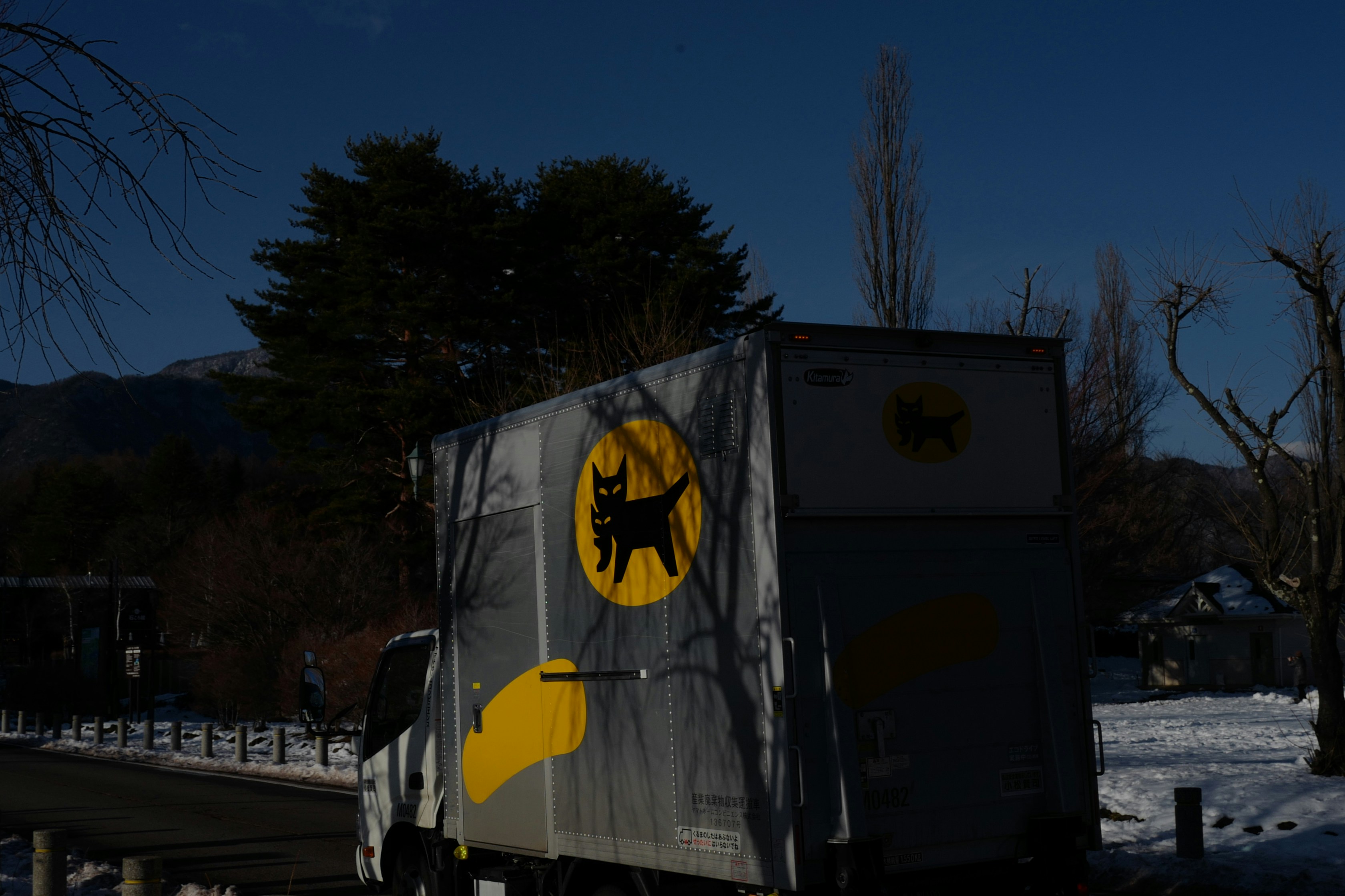 Blue Hour Freight: A Cat Emblem on a Snow-Touched Trailer