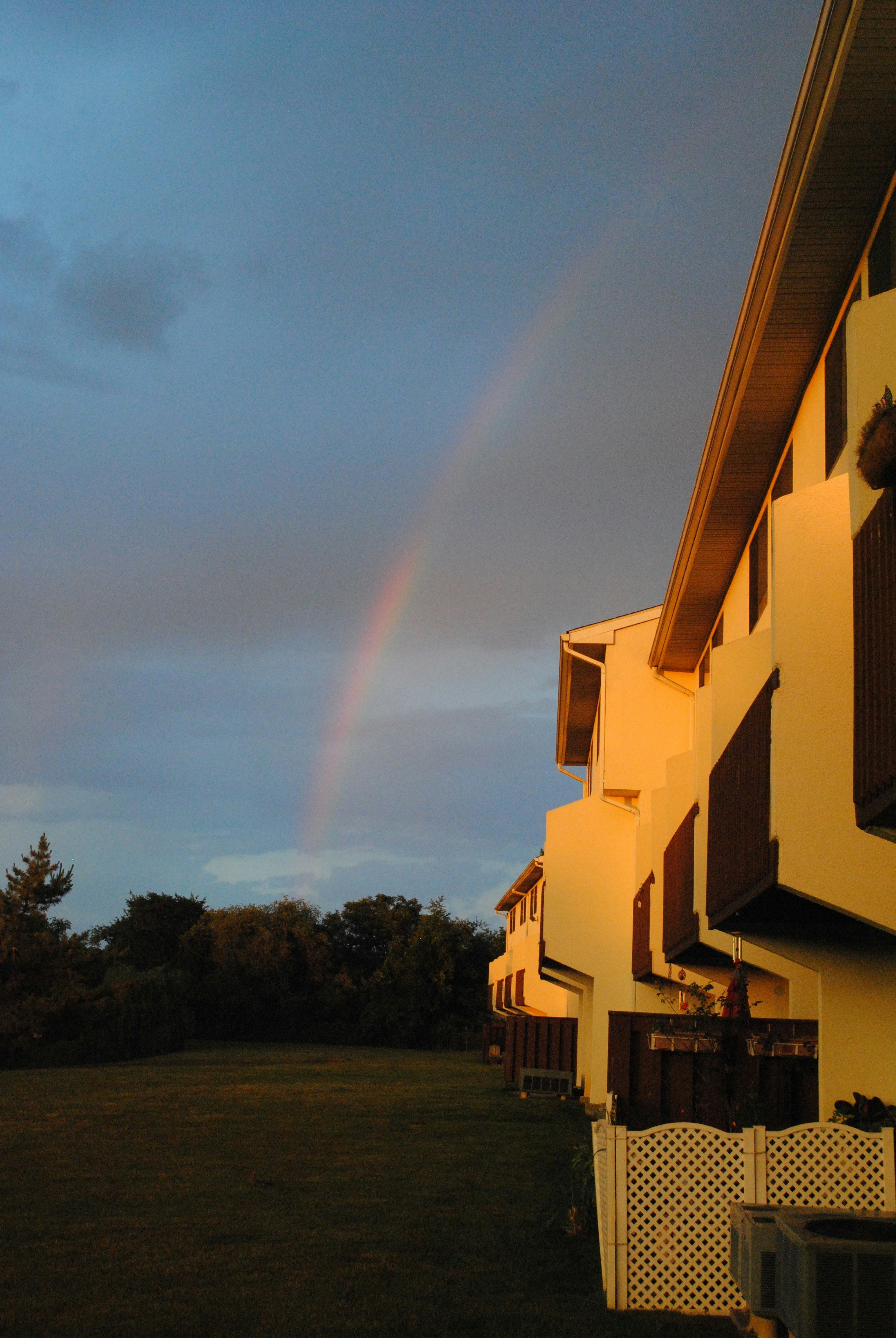 Rainbow Arc Over Sunlit Townhomes at Golden Hour