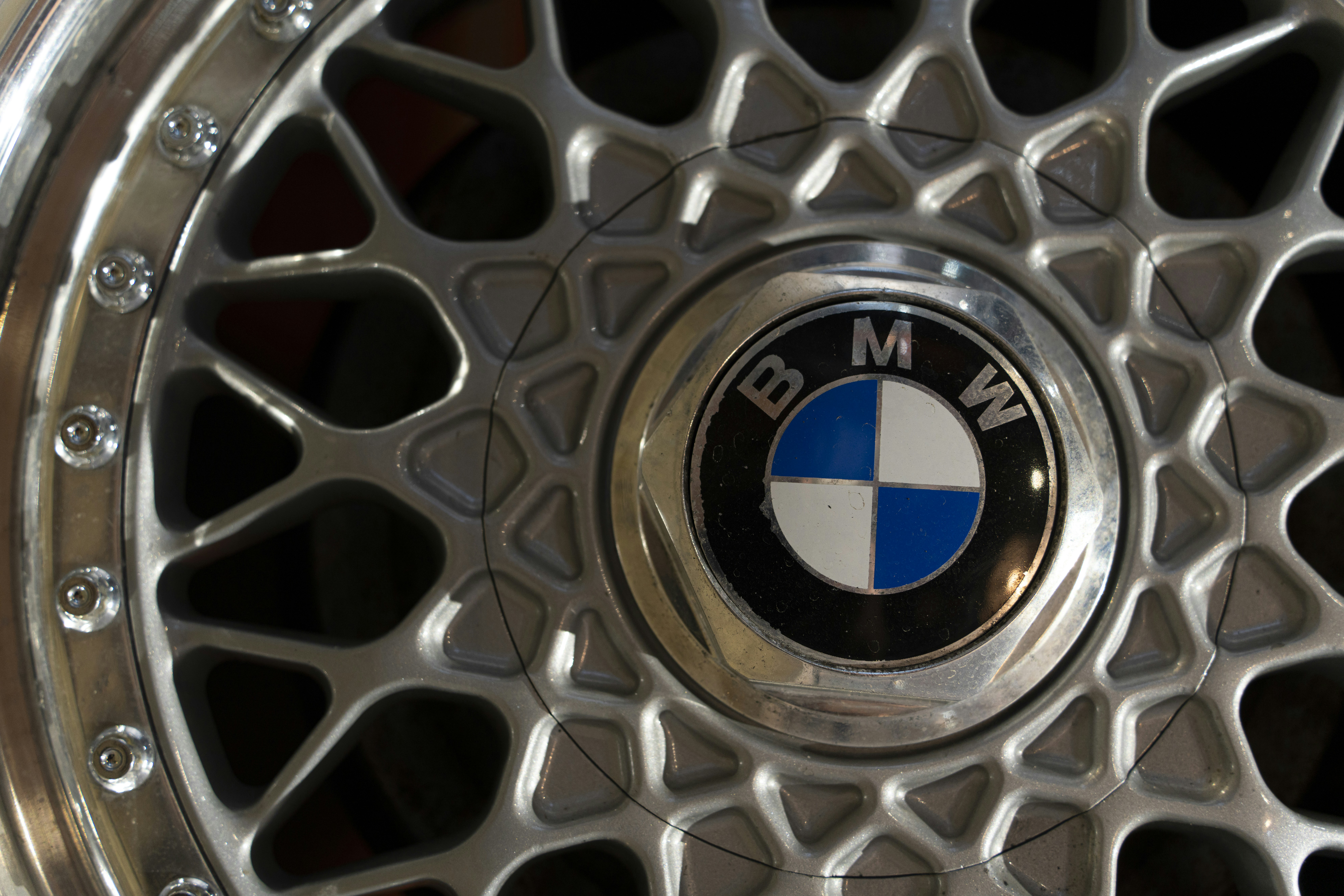 Mesh of chrome and badge: BMW emblem embedded in intricate wheel lattice