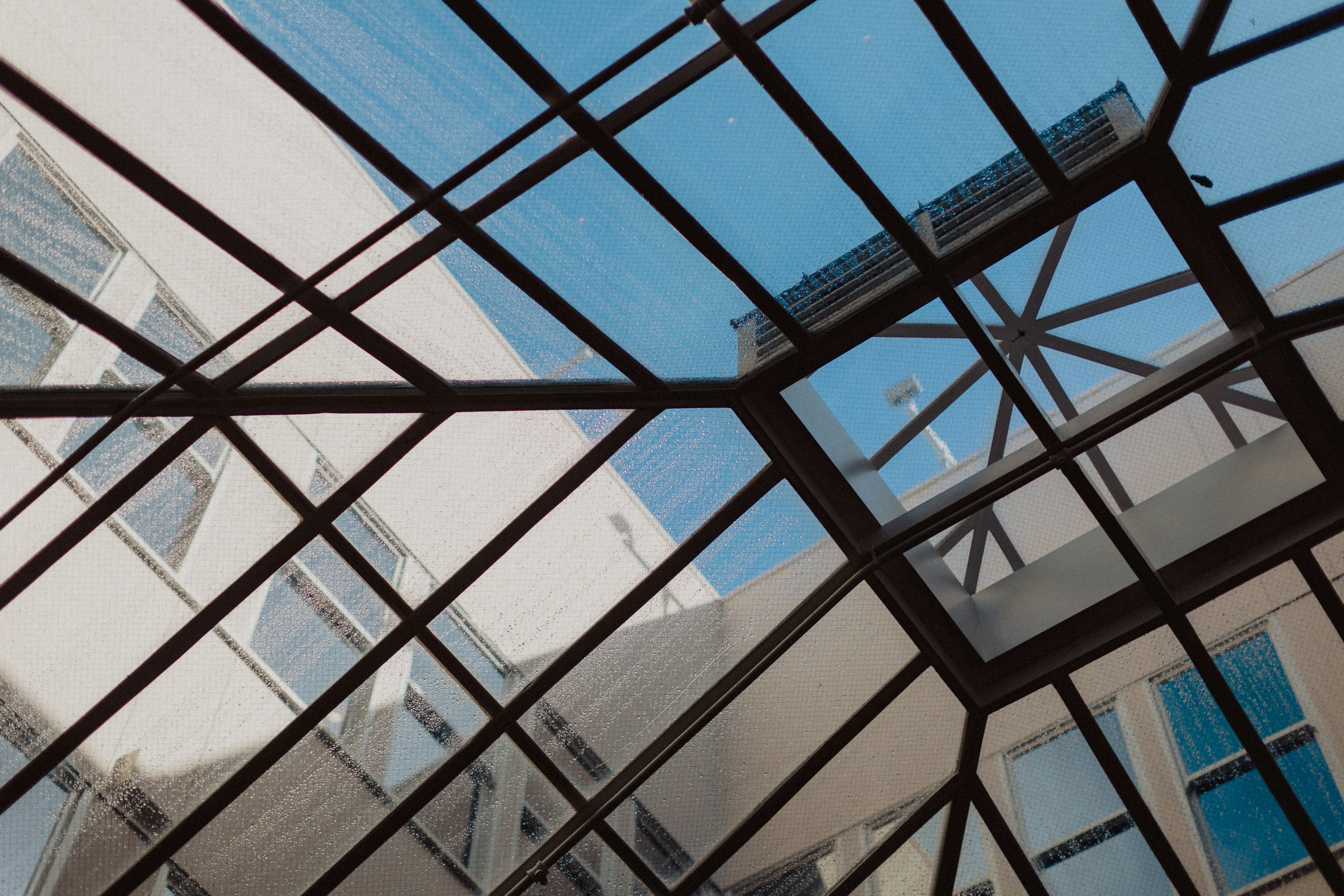 A view of a building through a glass roof photo – Free Building Image ...