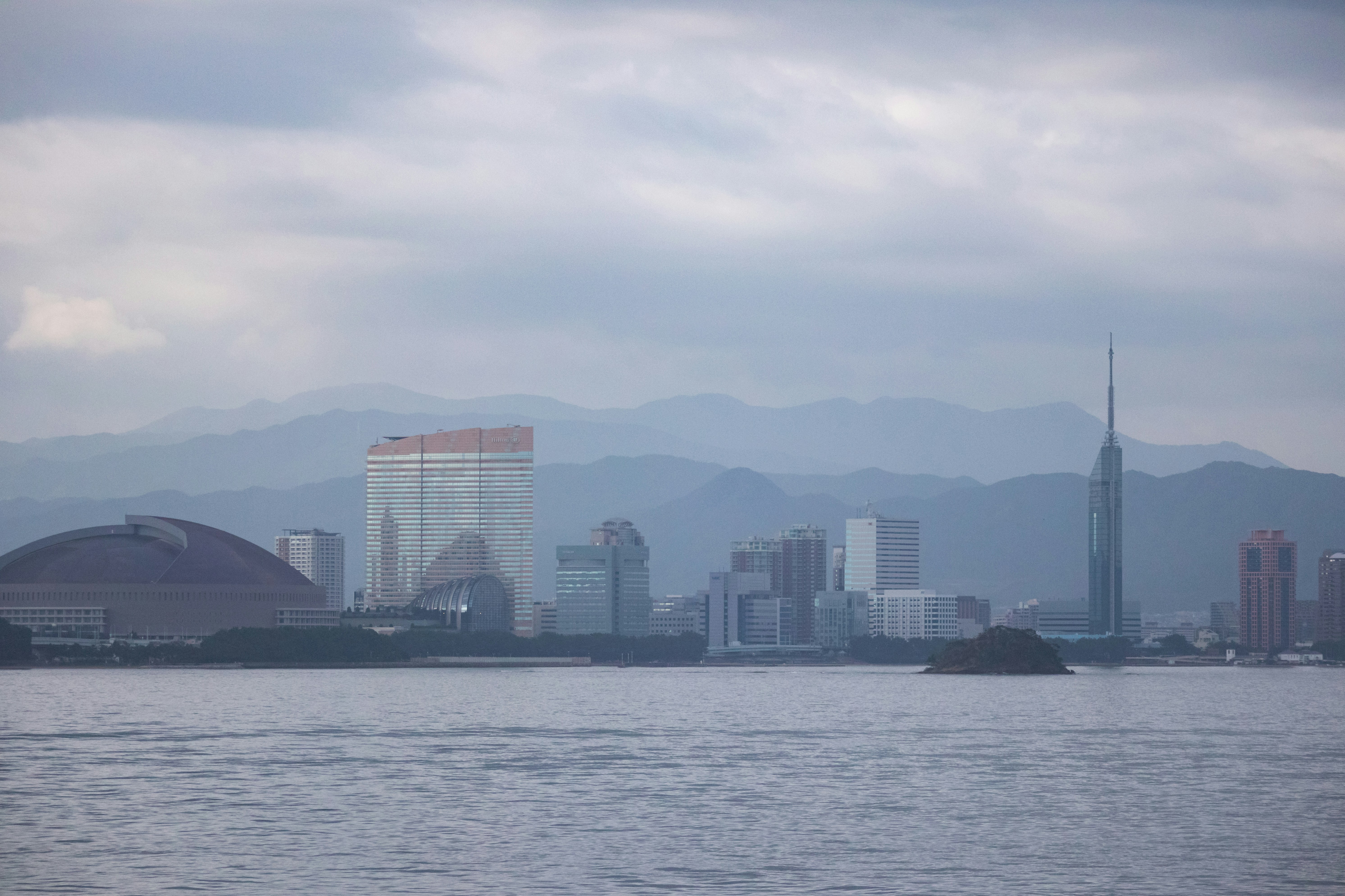 Distant Harbor Skyline Rising Through Misty Blue Mountains