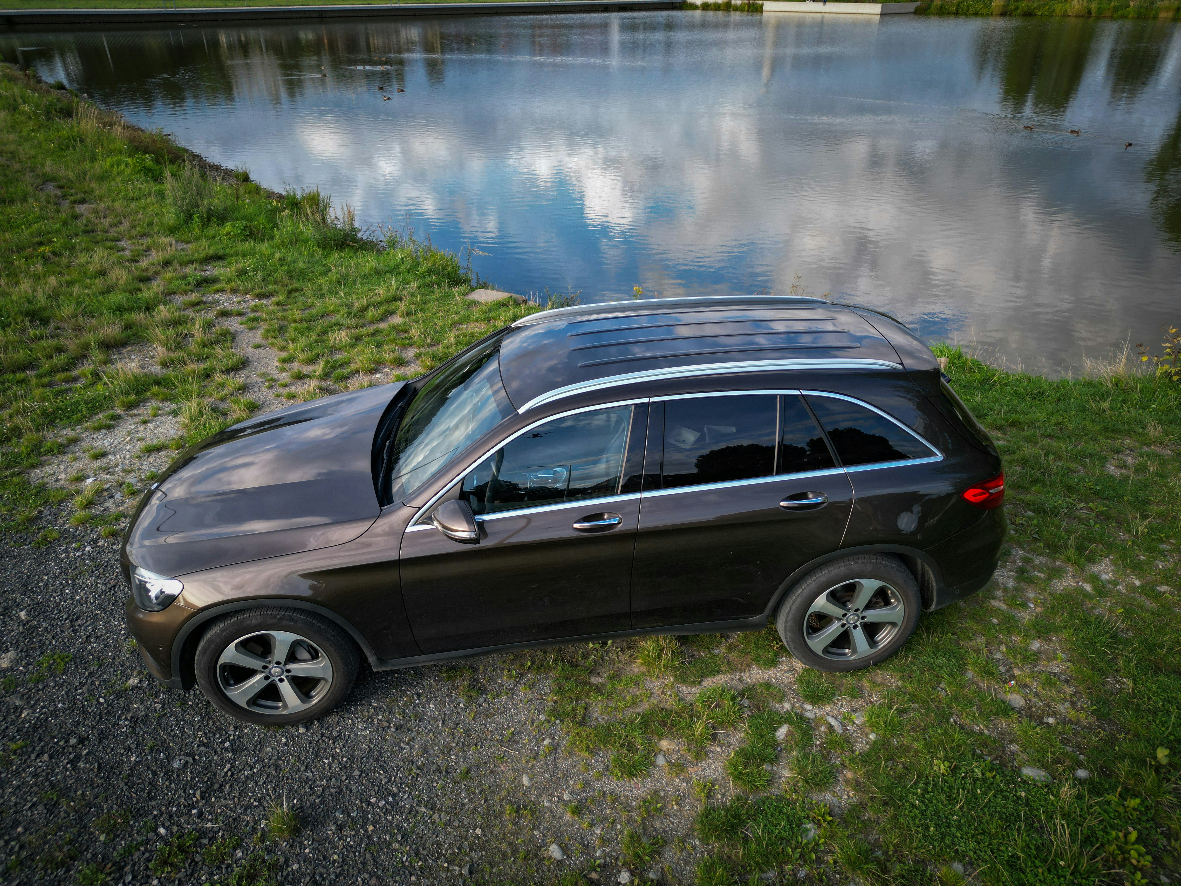 Lakeside Pause: A Bronze SUV Anchored by Quiet Waters