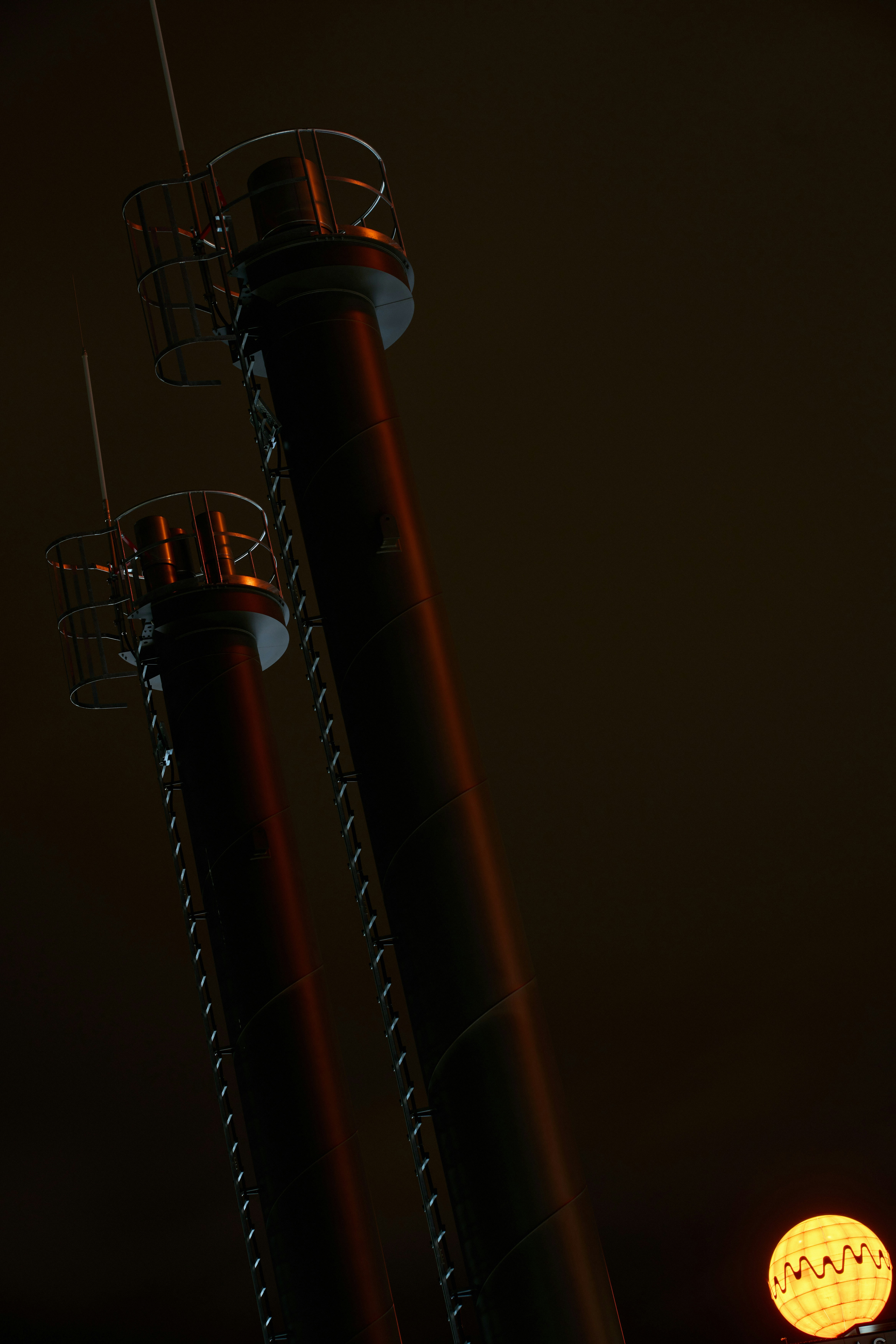 Ember-Touched Towers: Twin Industrial Chimneys Ascend into the Night