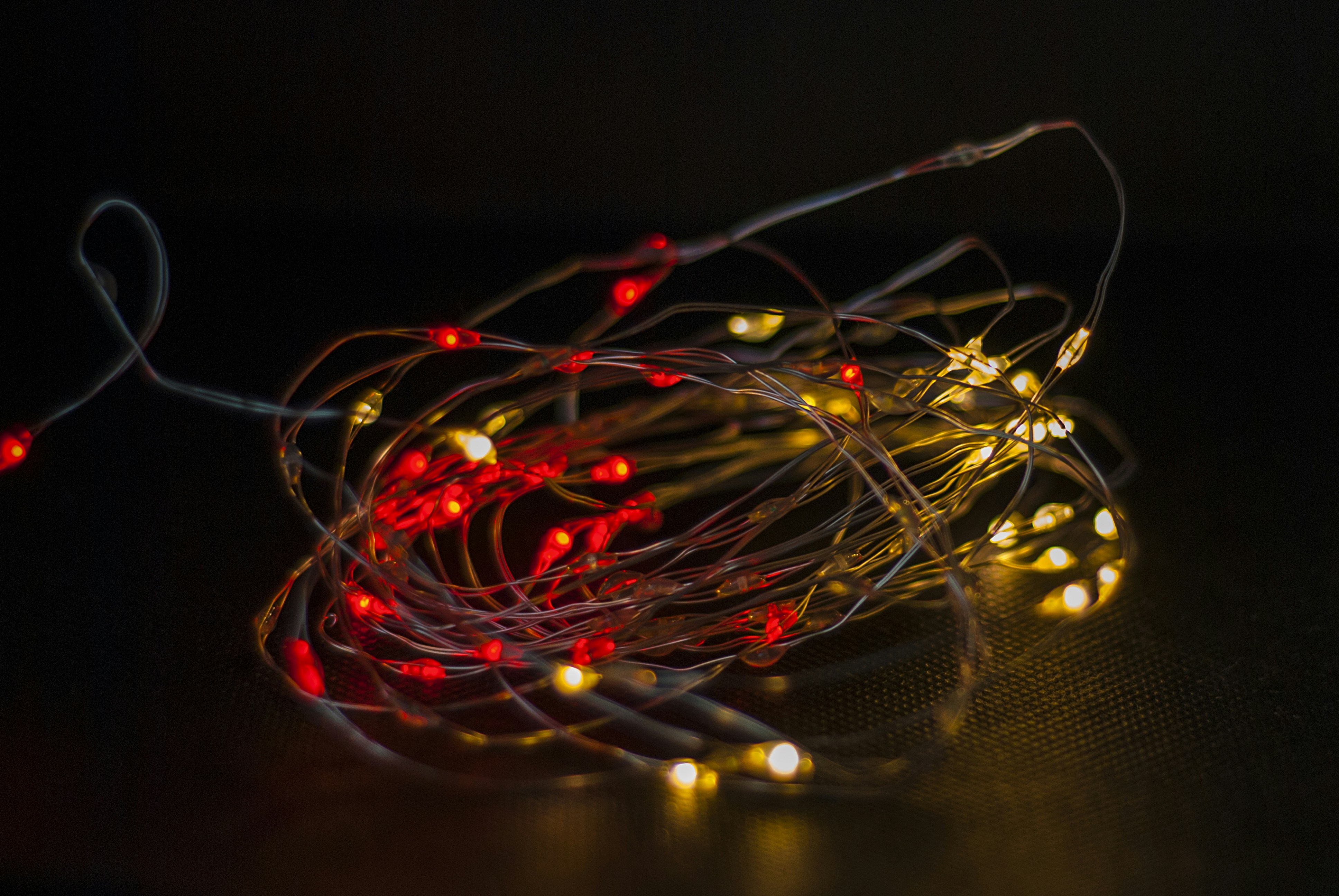 Tangled Glow: Red and Warm LED Threads in Velvet Darkness