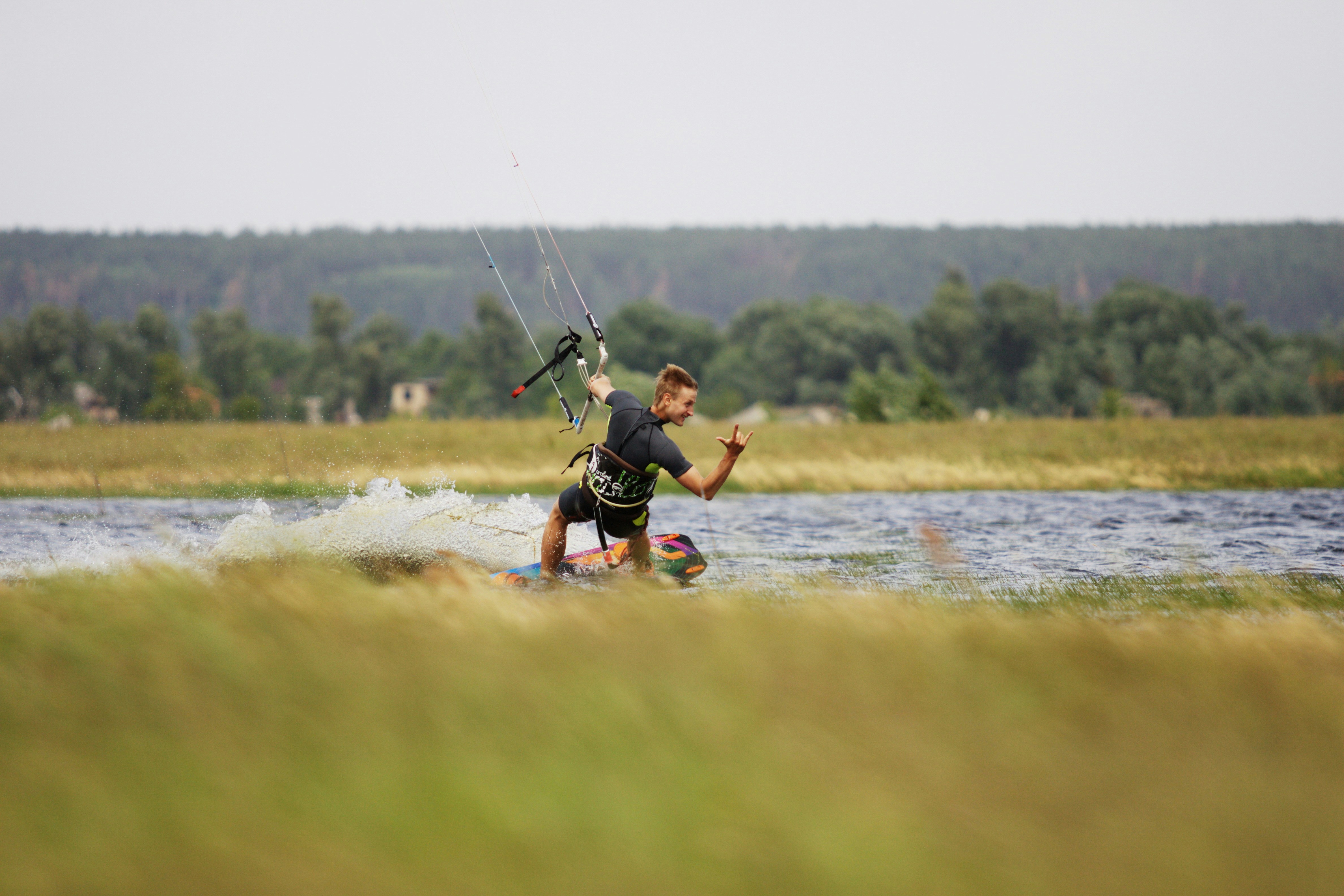 Spray and Glide: A Kite Surfer Carving Across a Glassy Lake