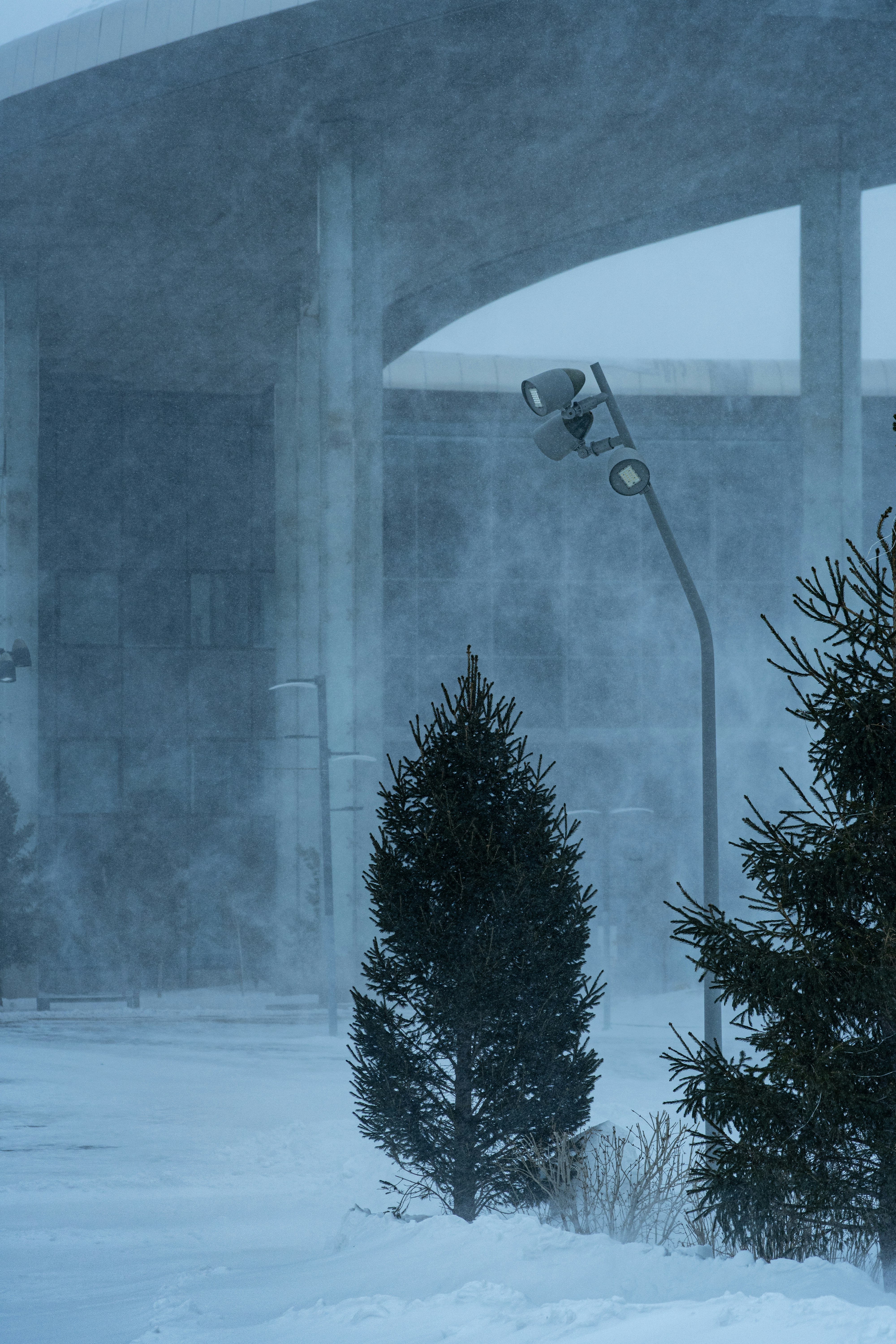 A street light in the snow with a bridge in the background photo – Free ...