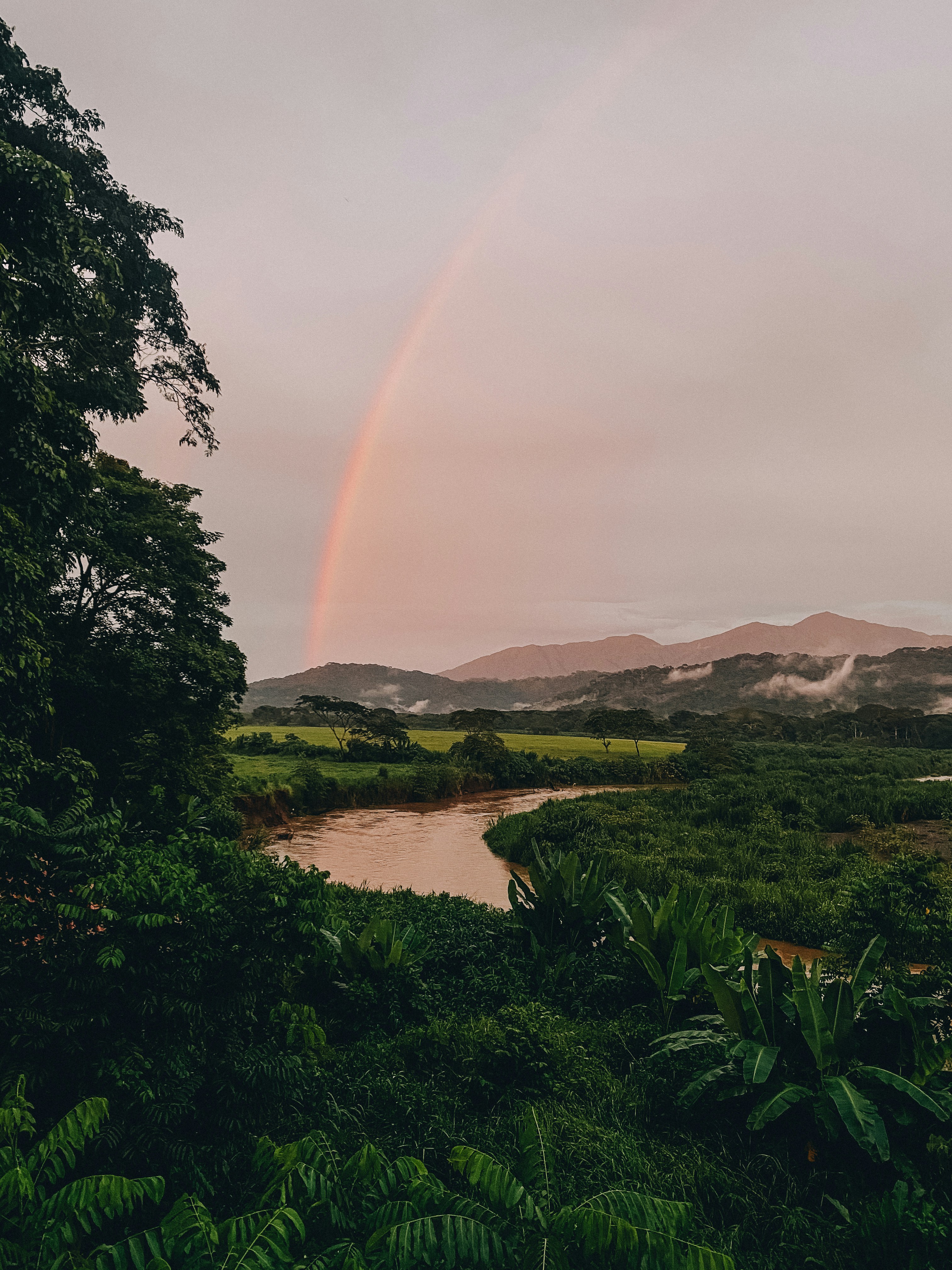 A rainbow shines in the sky over a river photo – Free Costa rica Image ...