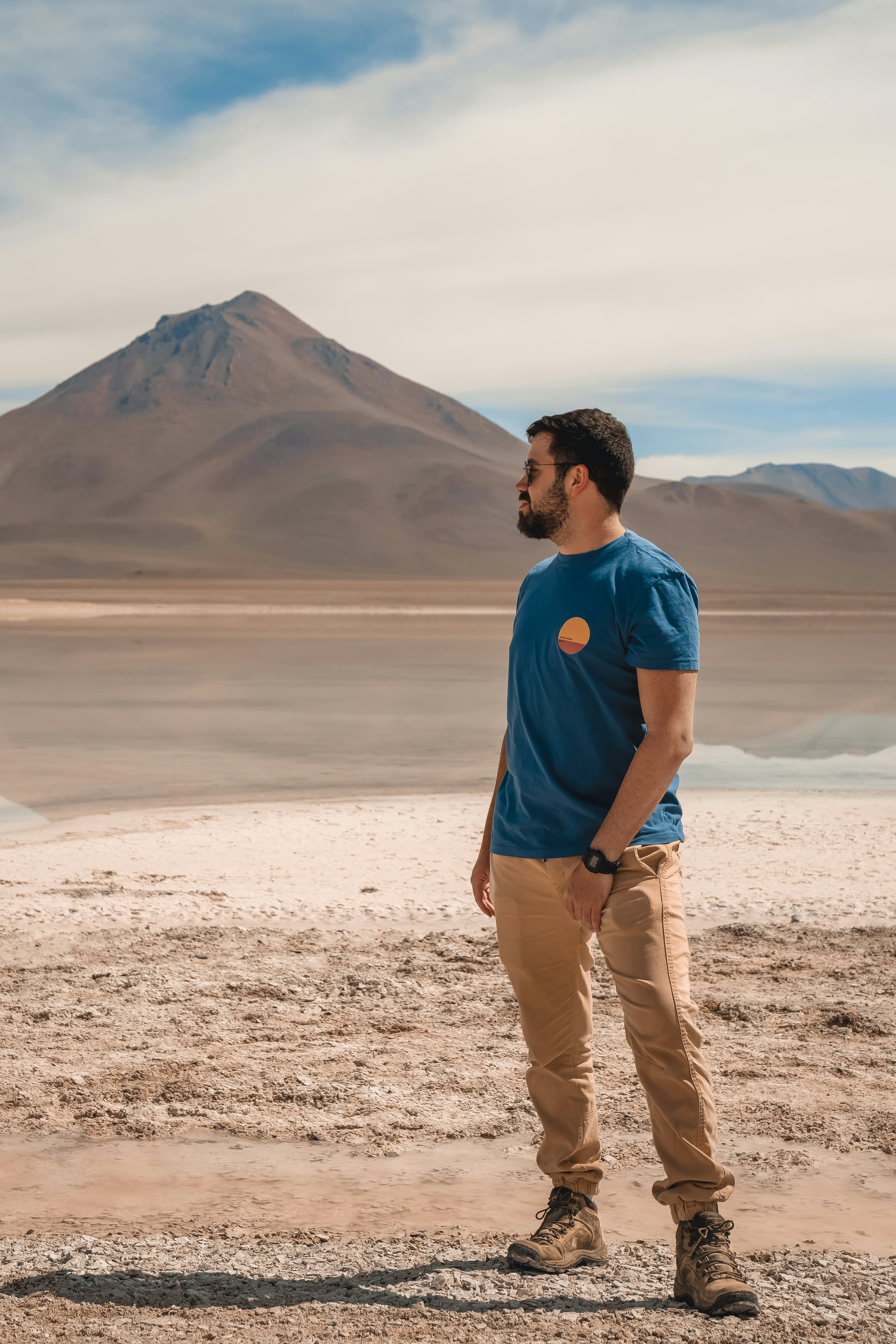 Blue Shirt at the Salt-Flat Horizon: A Quiet Stand Before the Volcanic Crest