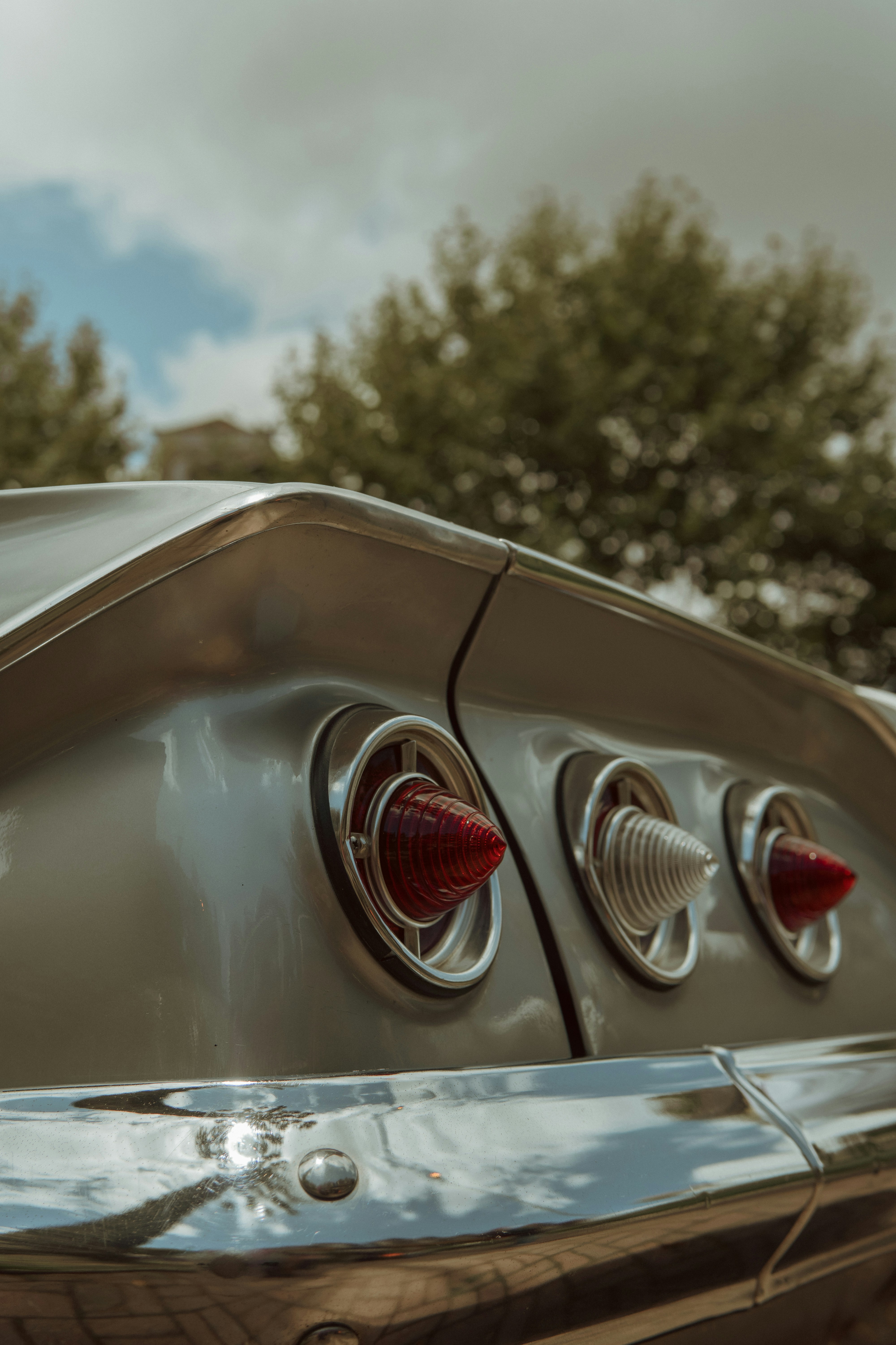 Chrome tailfin echoes the past: close-up of vintage car taillights