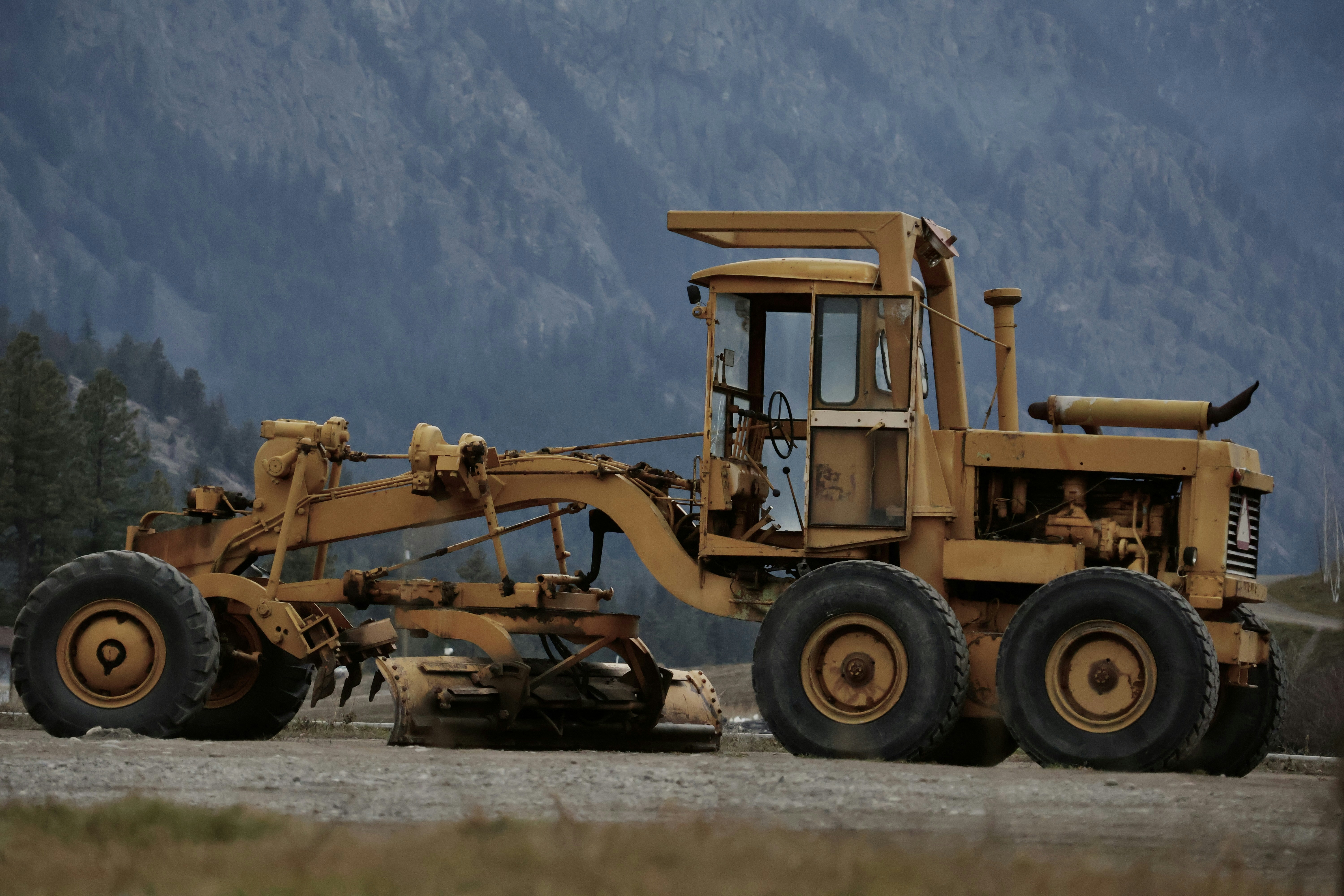Rust on Gravel: A Weathered Bulldozer Against Alpine Silence