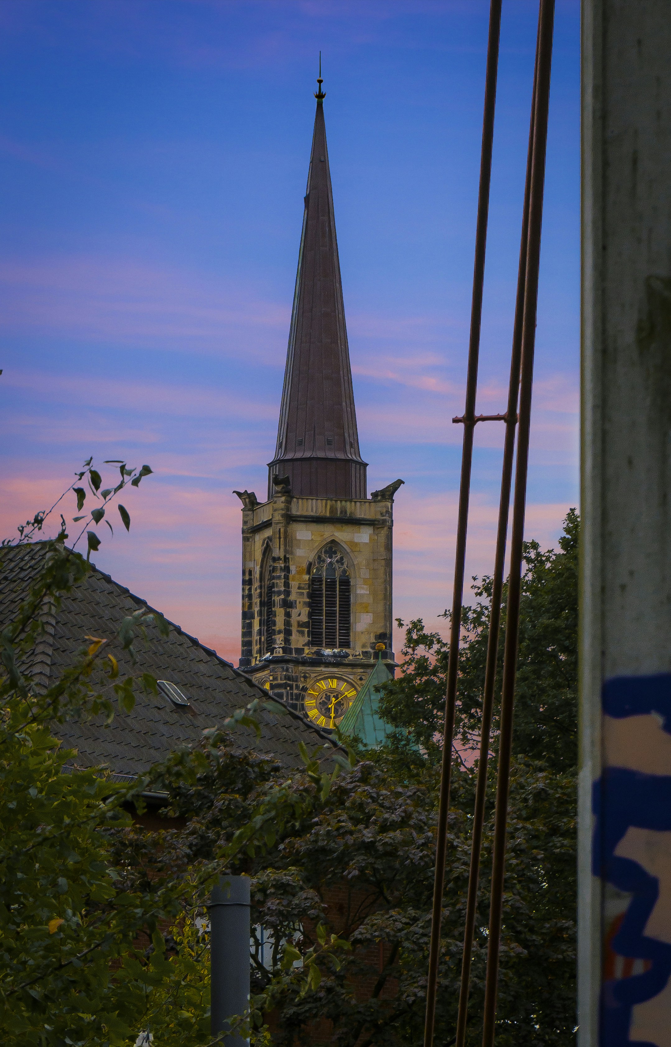 Dusk Spire Between Rails: A Clock Tower Emerges Over Rooftop Alley