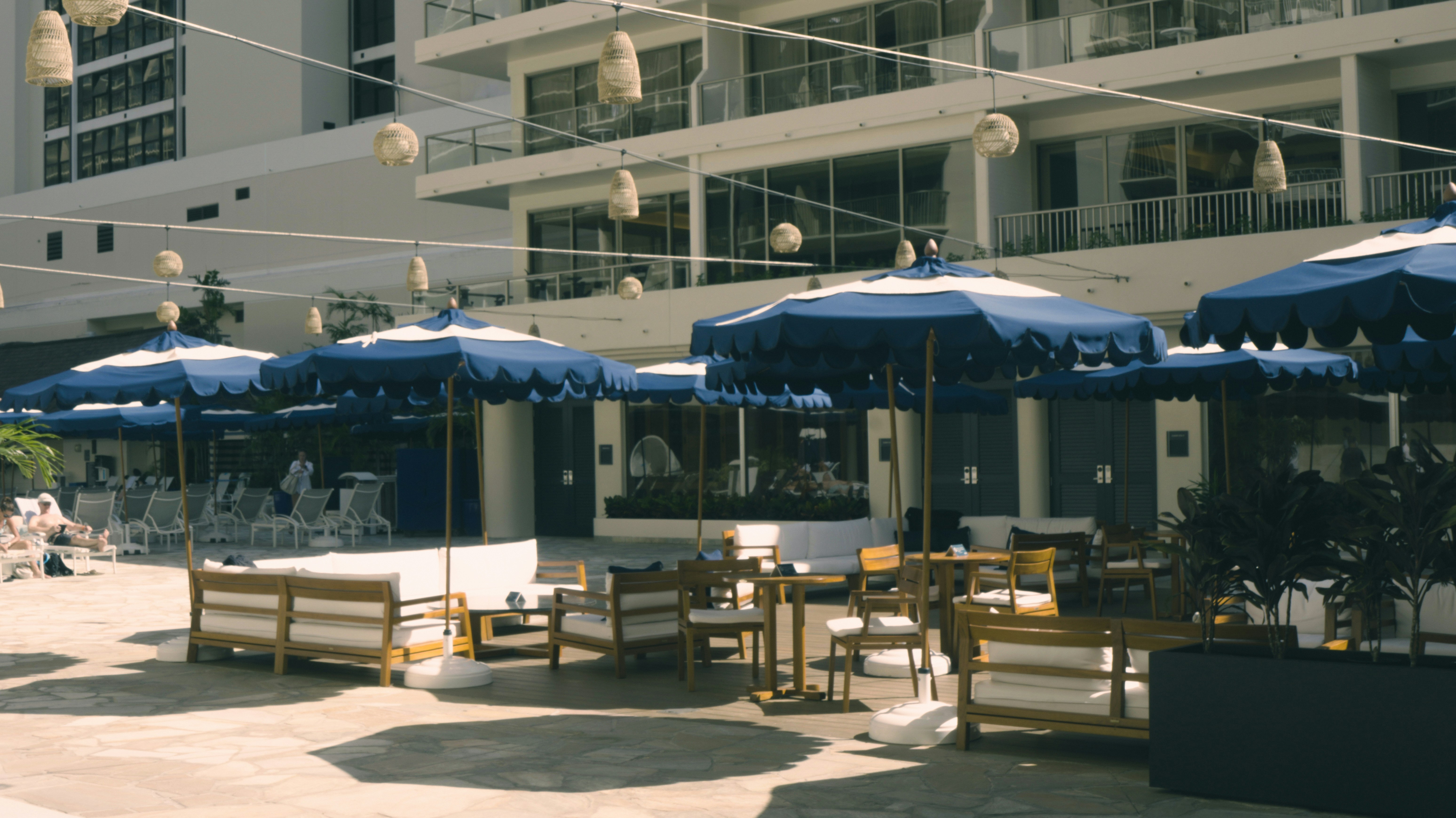 A group of tables and chairs with blue umbrellas photo – Free City ...