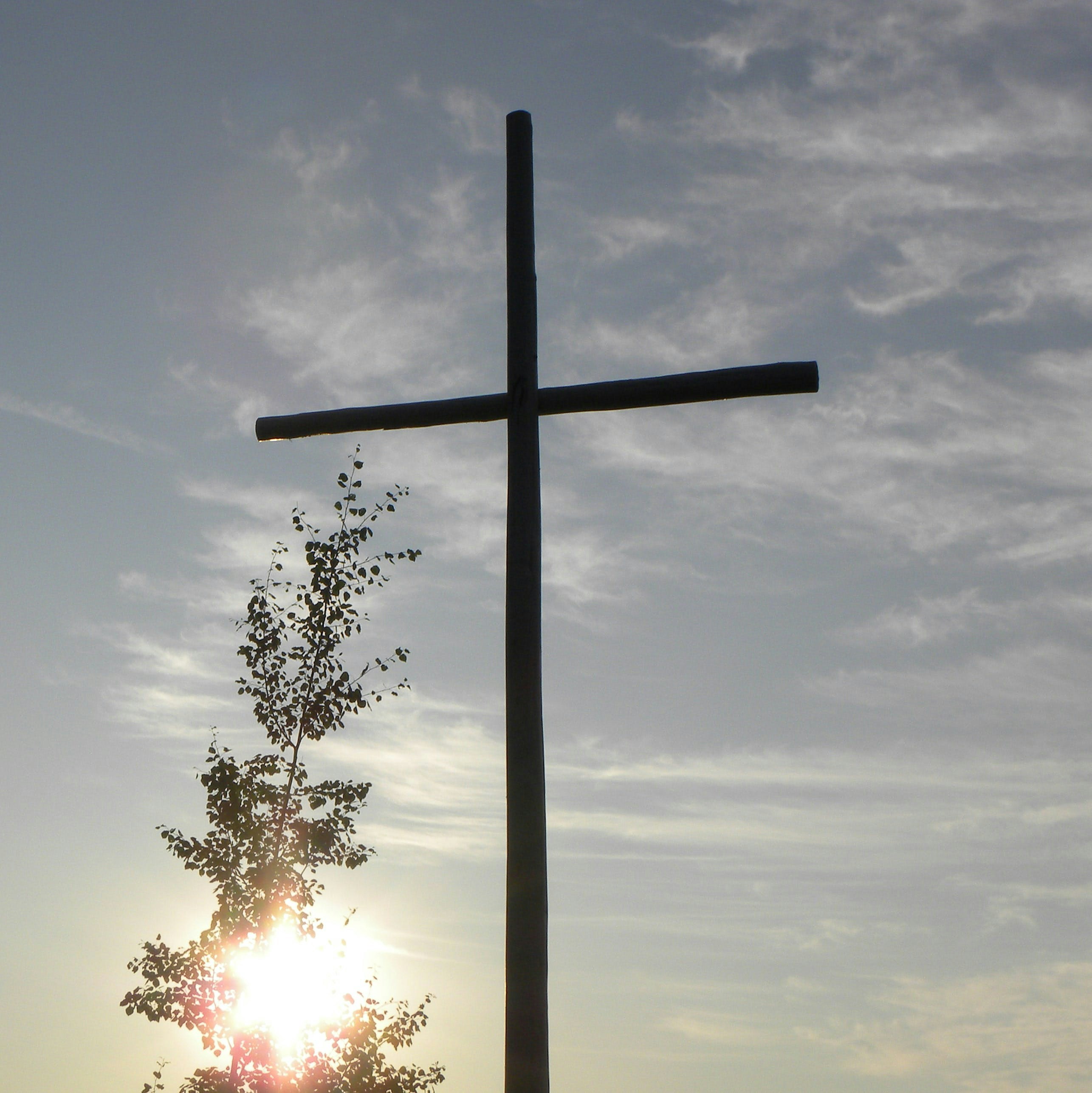 A cross on top of a hill with the sun behind it photo – Free Religious ...