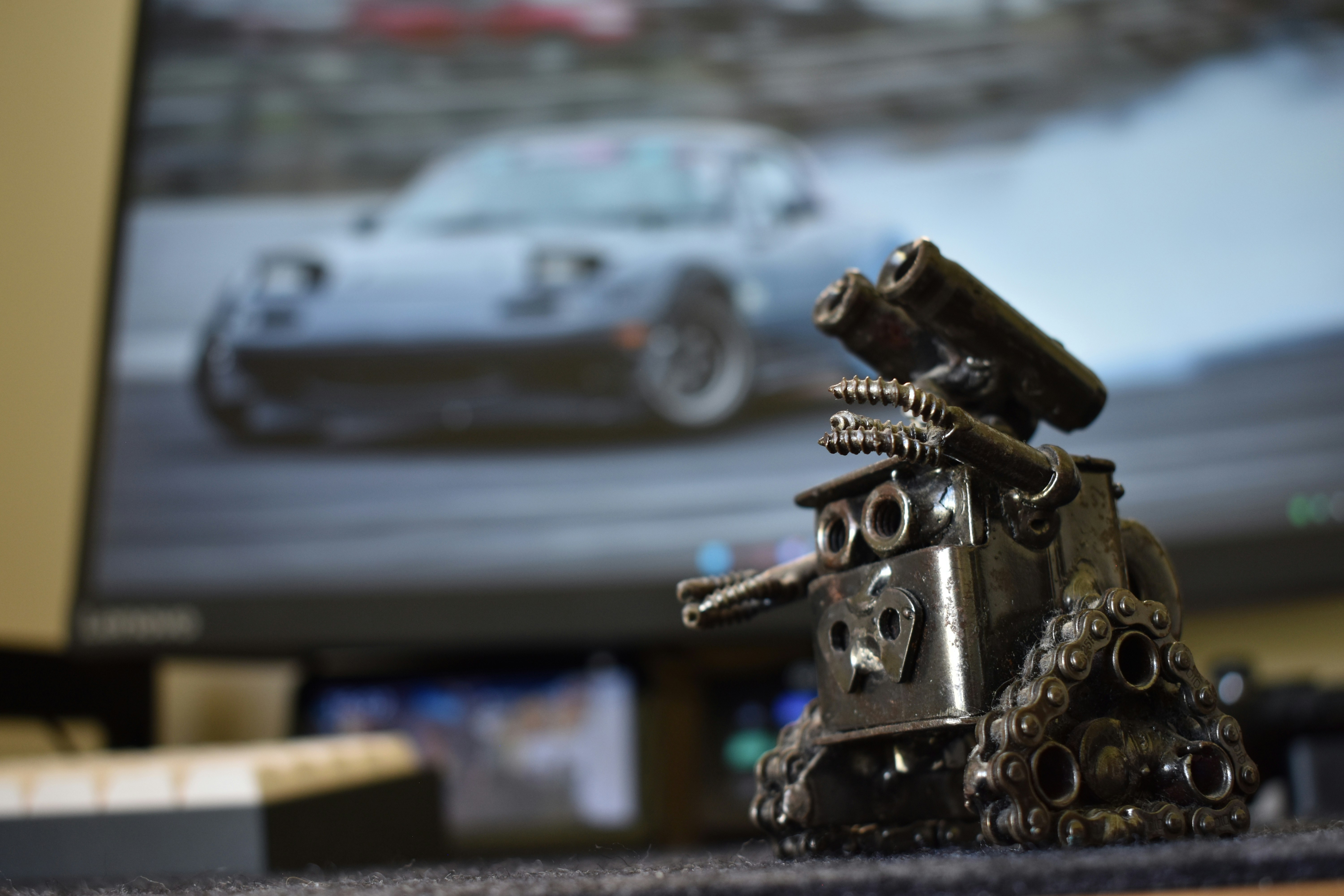 a metal sculpture of a car on a desk