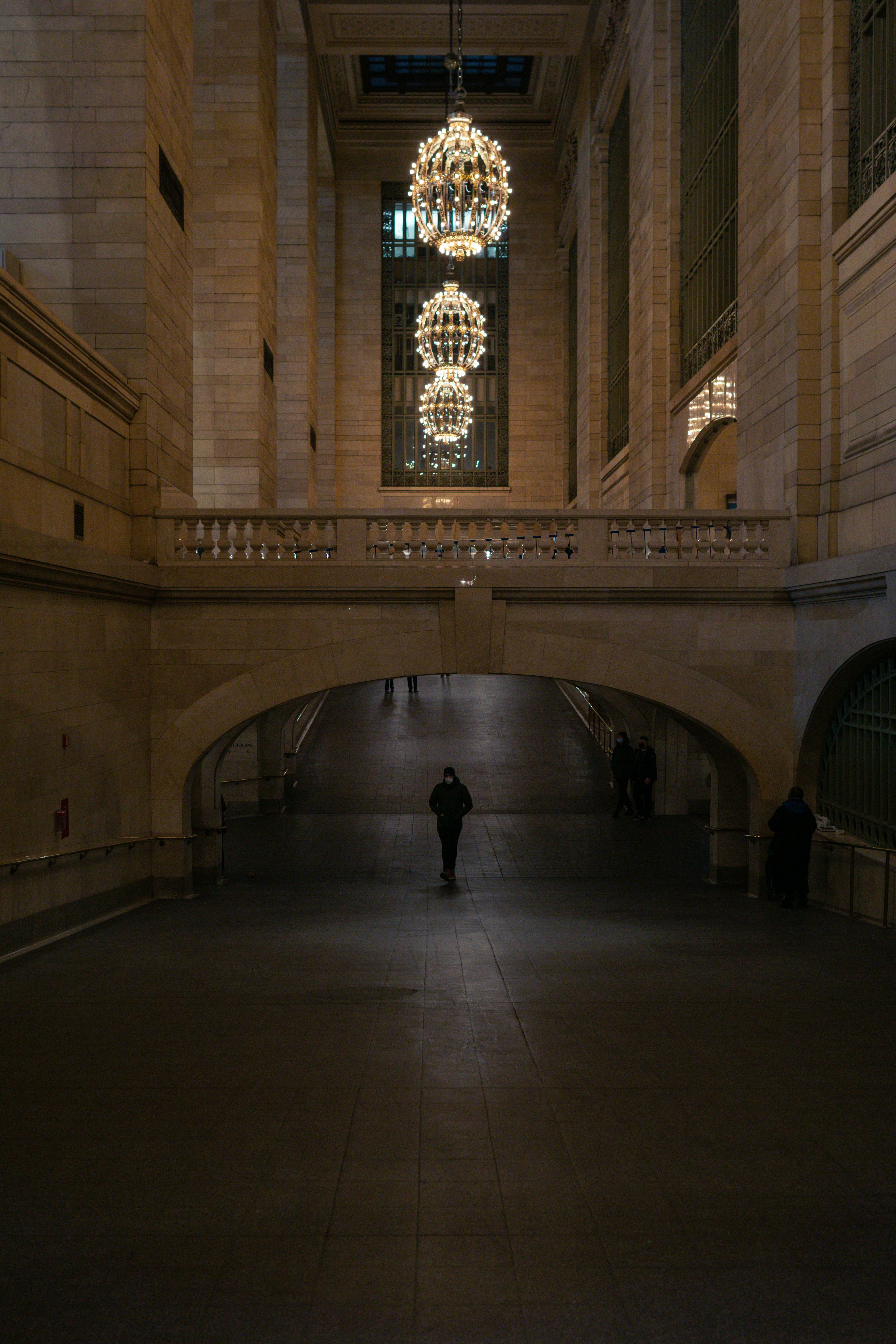 A person standing in a large building with a chandelier photo – Free ...
