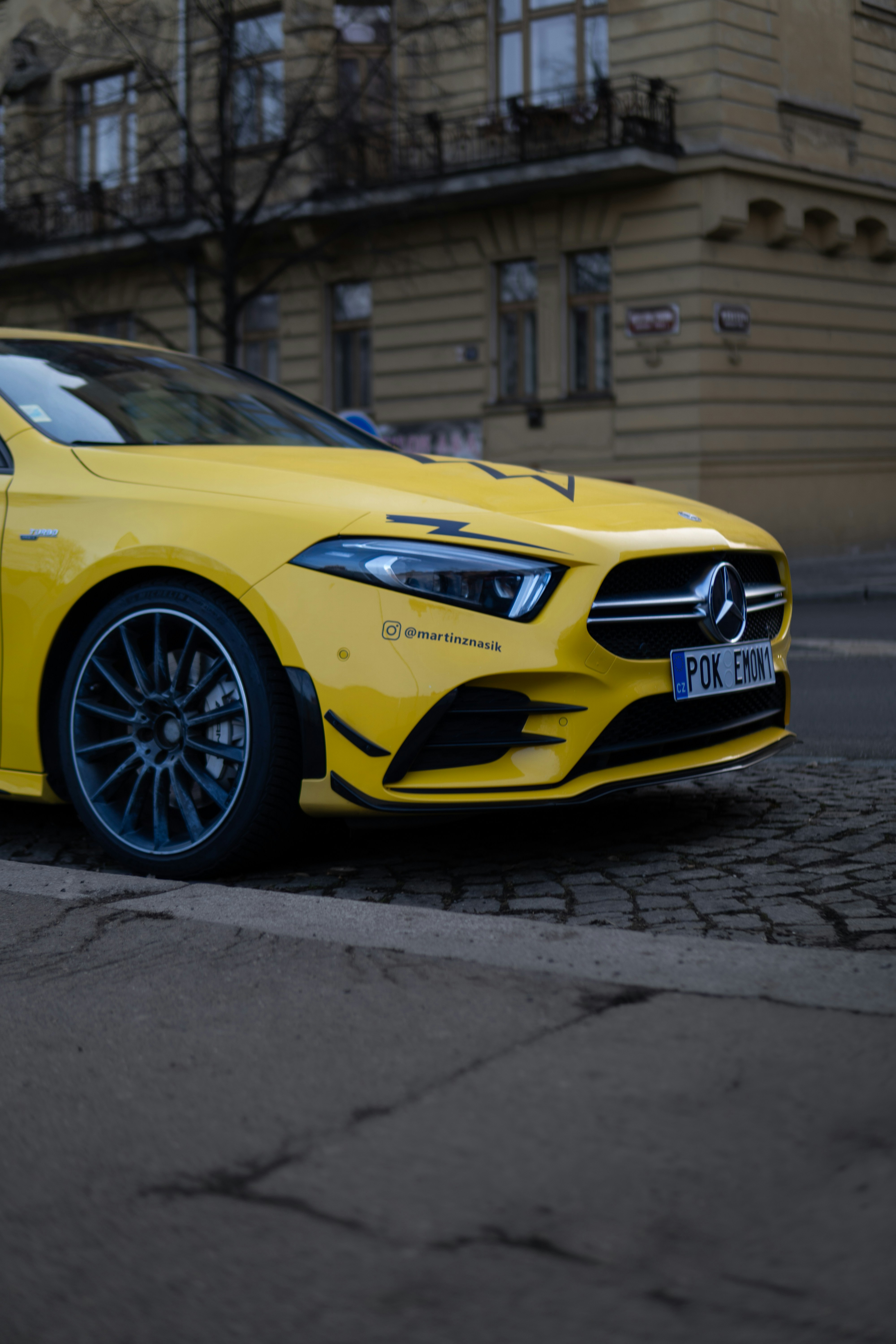 Sunlit Yellow Mercedes on a City Cobblestone Street