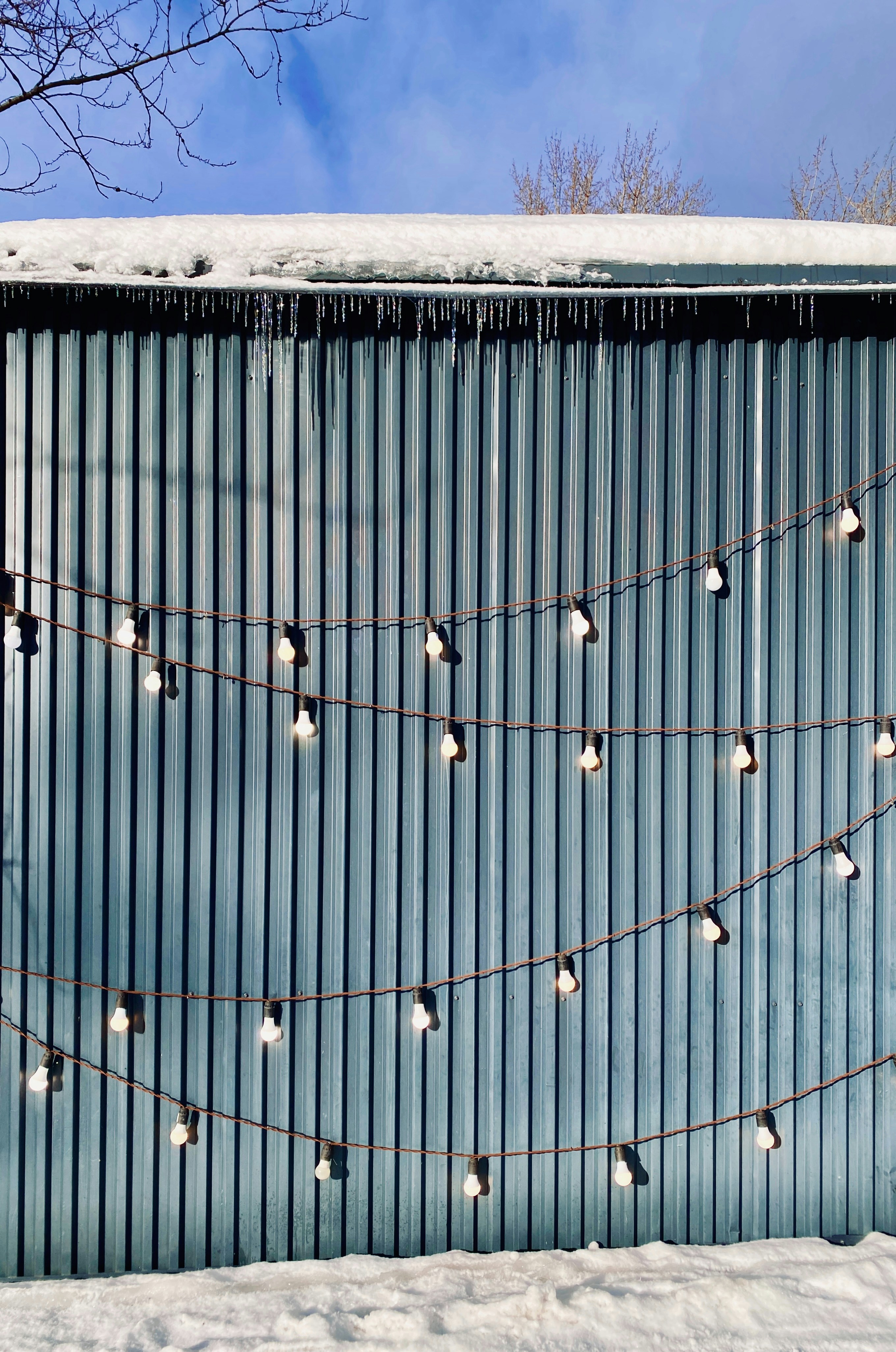 Warm Bulbs Across a Frosted Blue Corrugated Wall