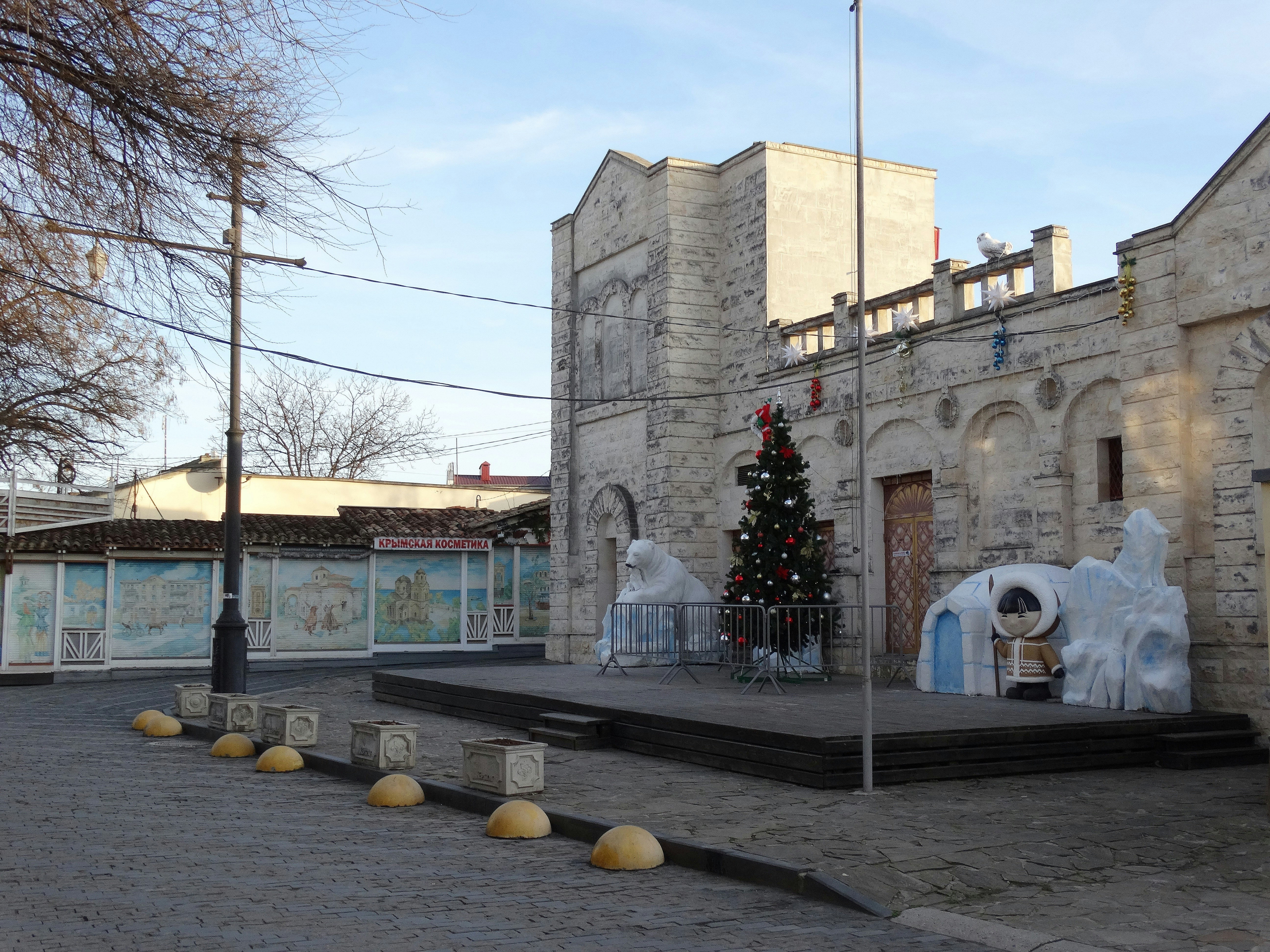 Midwinter Tableau: Christmas Tree Framed by Ice Sculptures in a Stone Courtyard