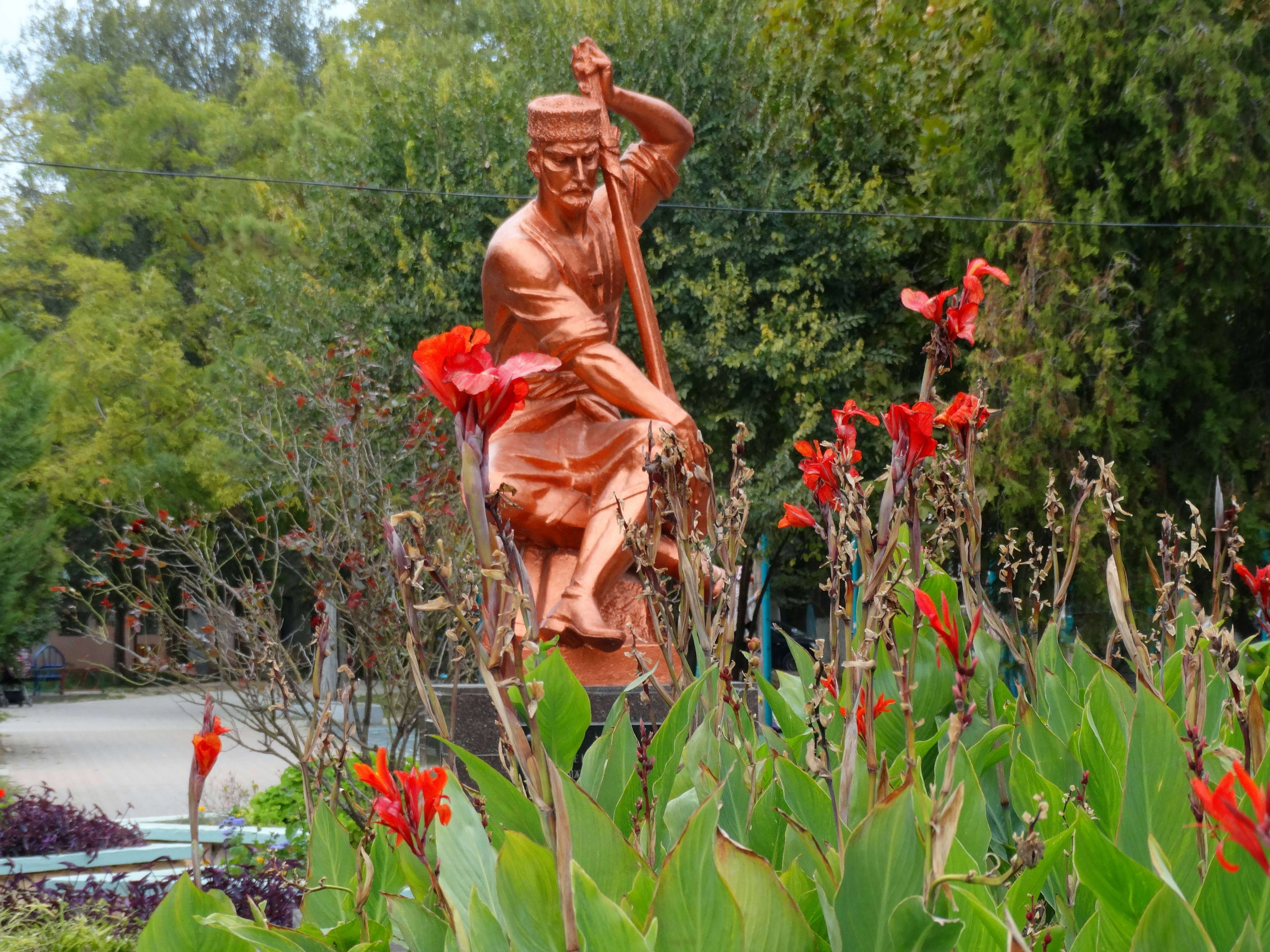 Copper Sentinel in a Garden of Crimson Blooms