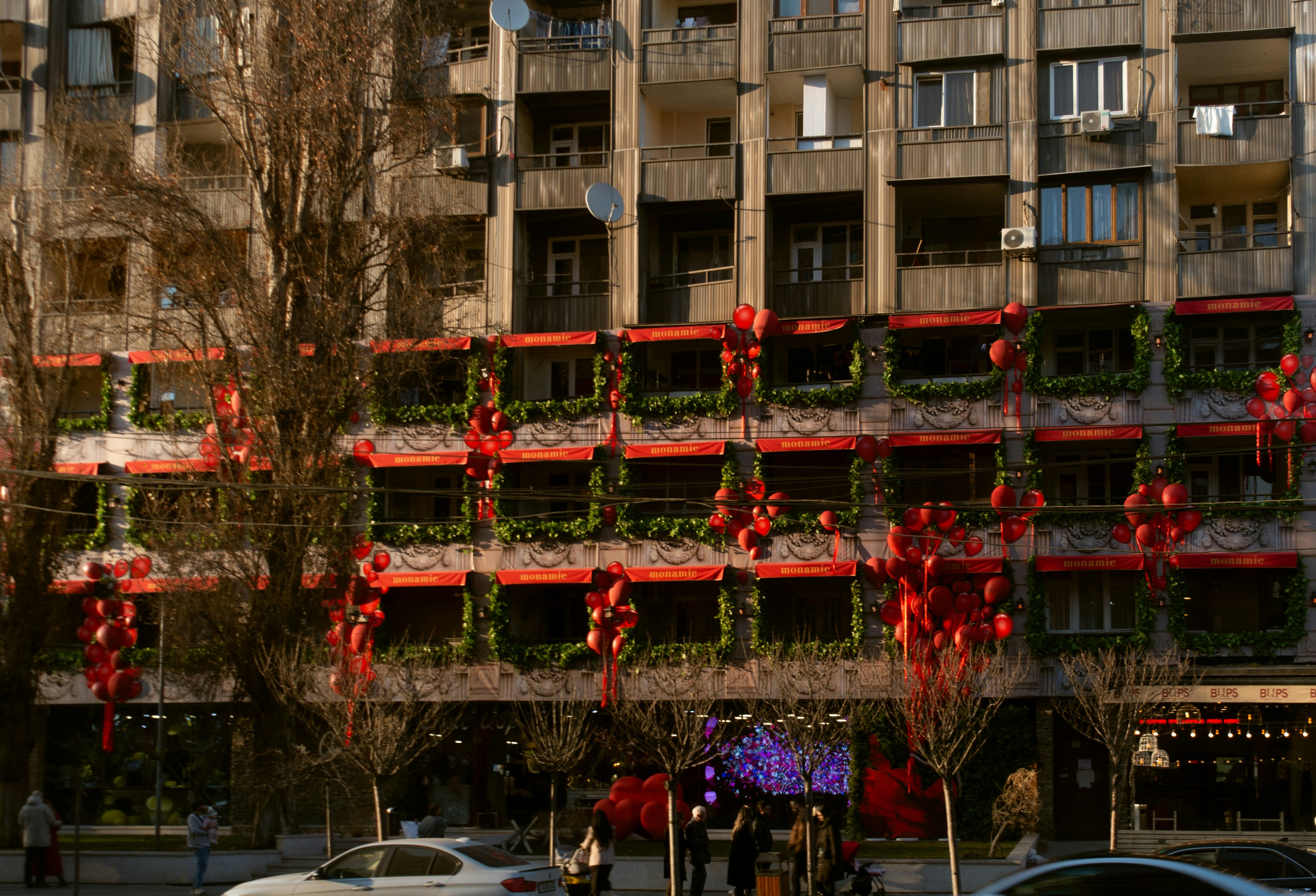 A tall building with a bunch of red ribbons hanging from it's sides ...