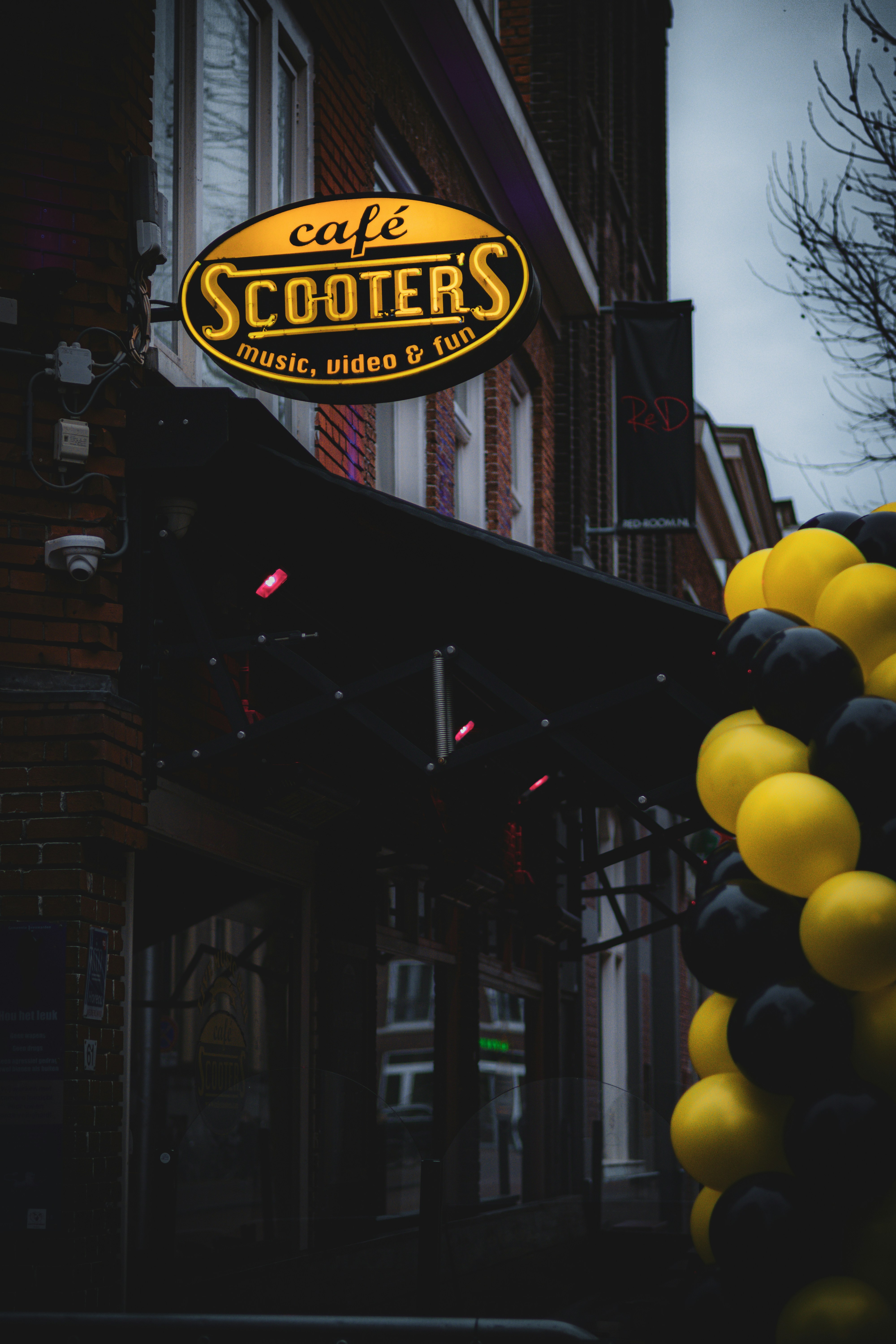 Scooter's Café Sign at Dusk: Balloons Framing a Quiet Street