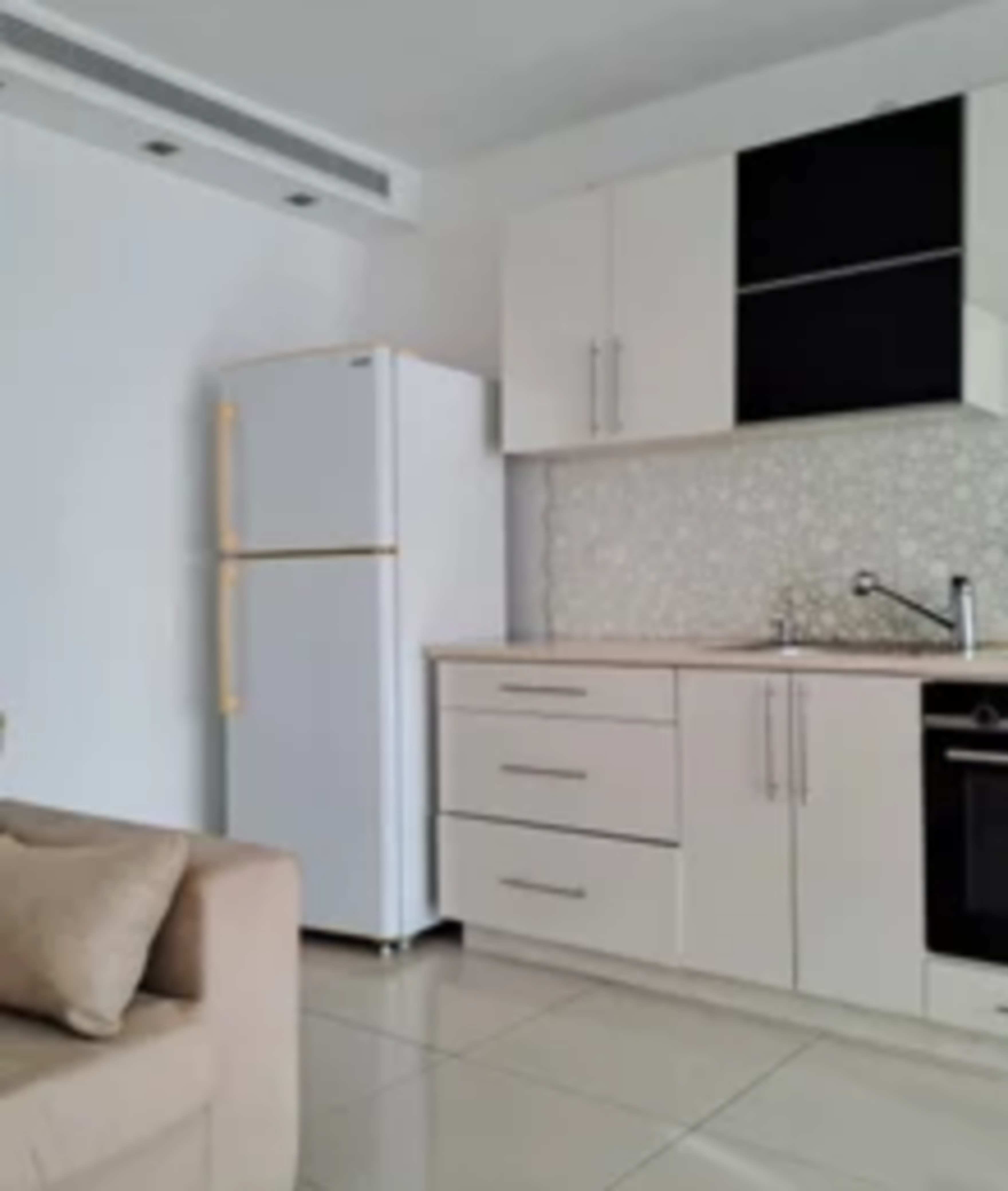 A living room with a couch a refrigerator and cabinets photo – Free ...