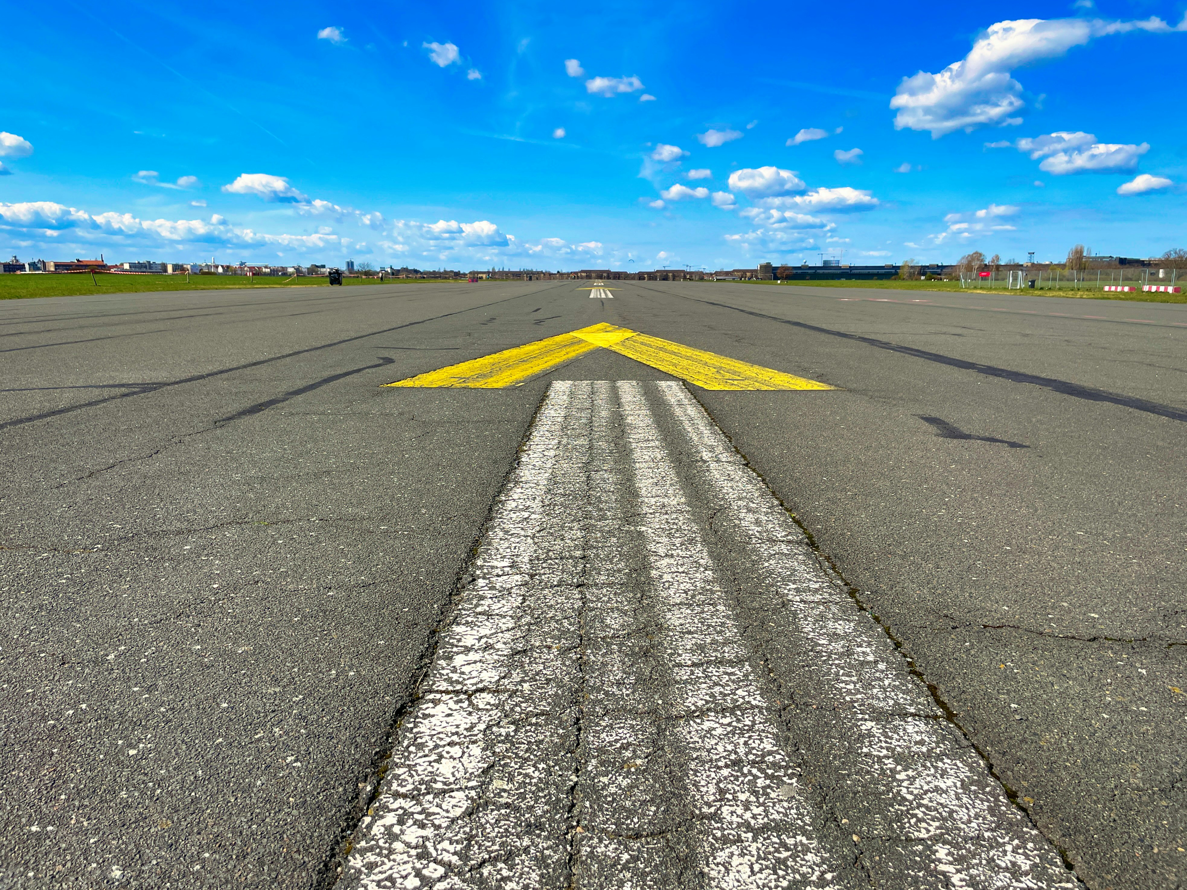 A yellow arrow painted on an empty runway photo – Free Tempelhof Image ...