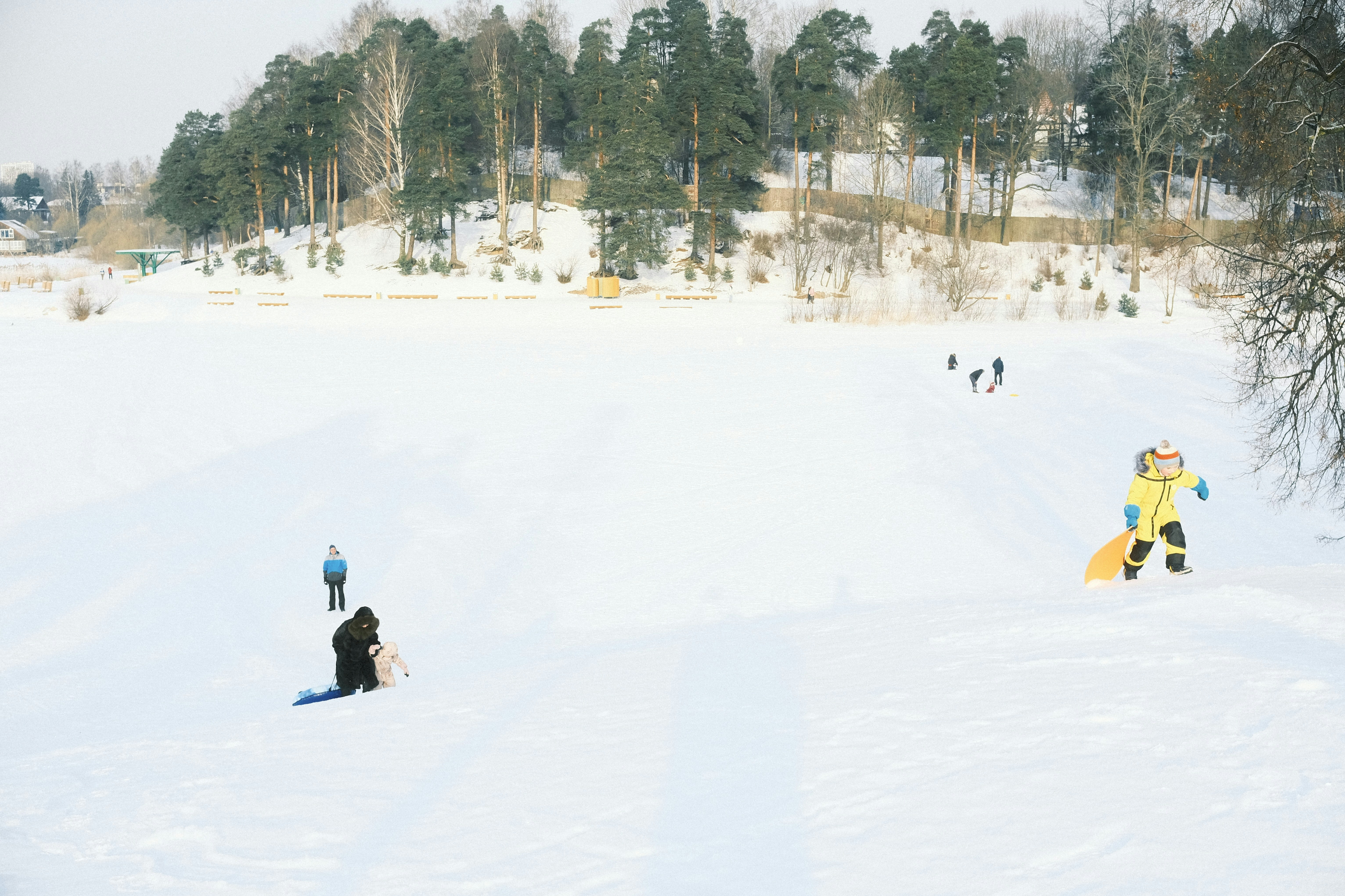 A group of people riding snowboards down a snow covered slope photo ...