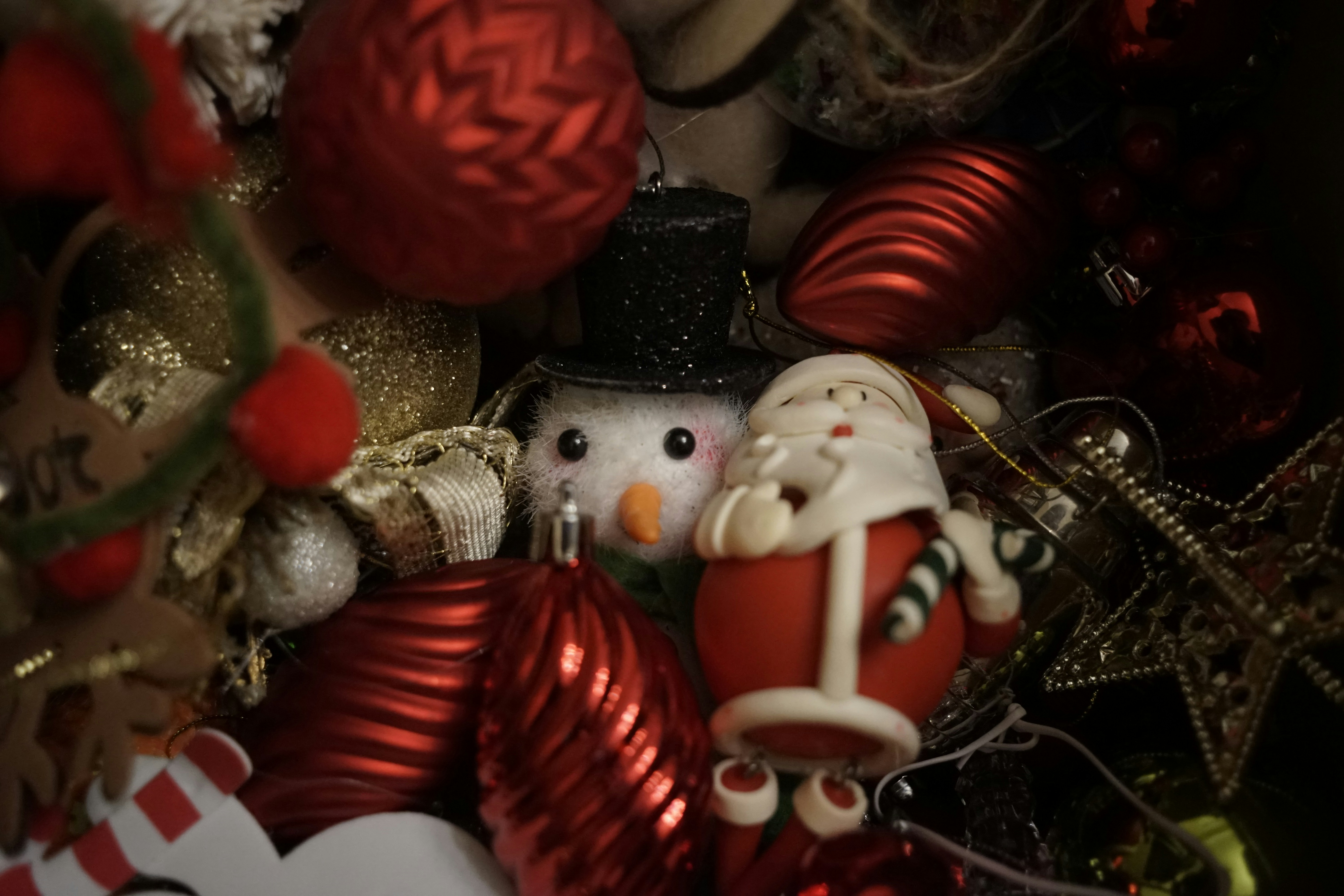 a close up of a snowman ornament surrounded by christmas ornaments
