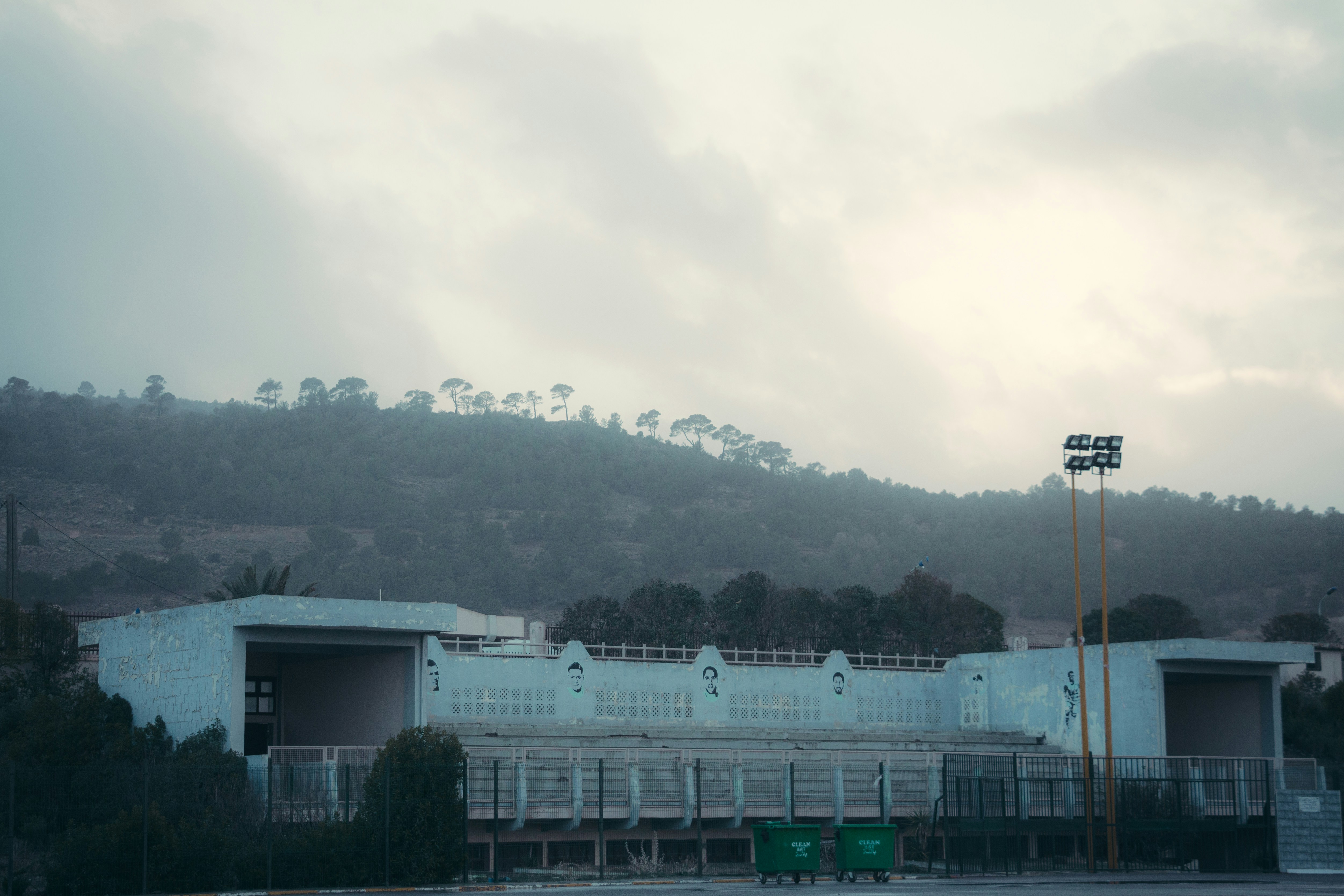 Azure Stadium Facade Beneath a Cloudy Horizon
