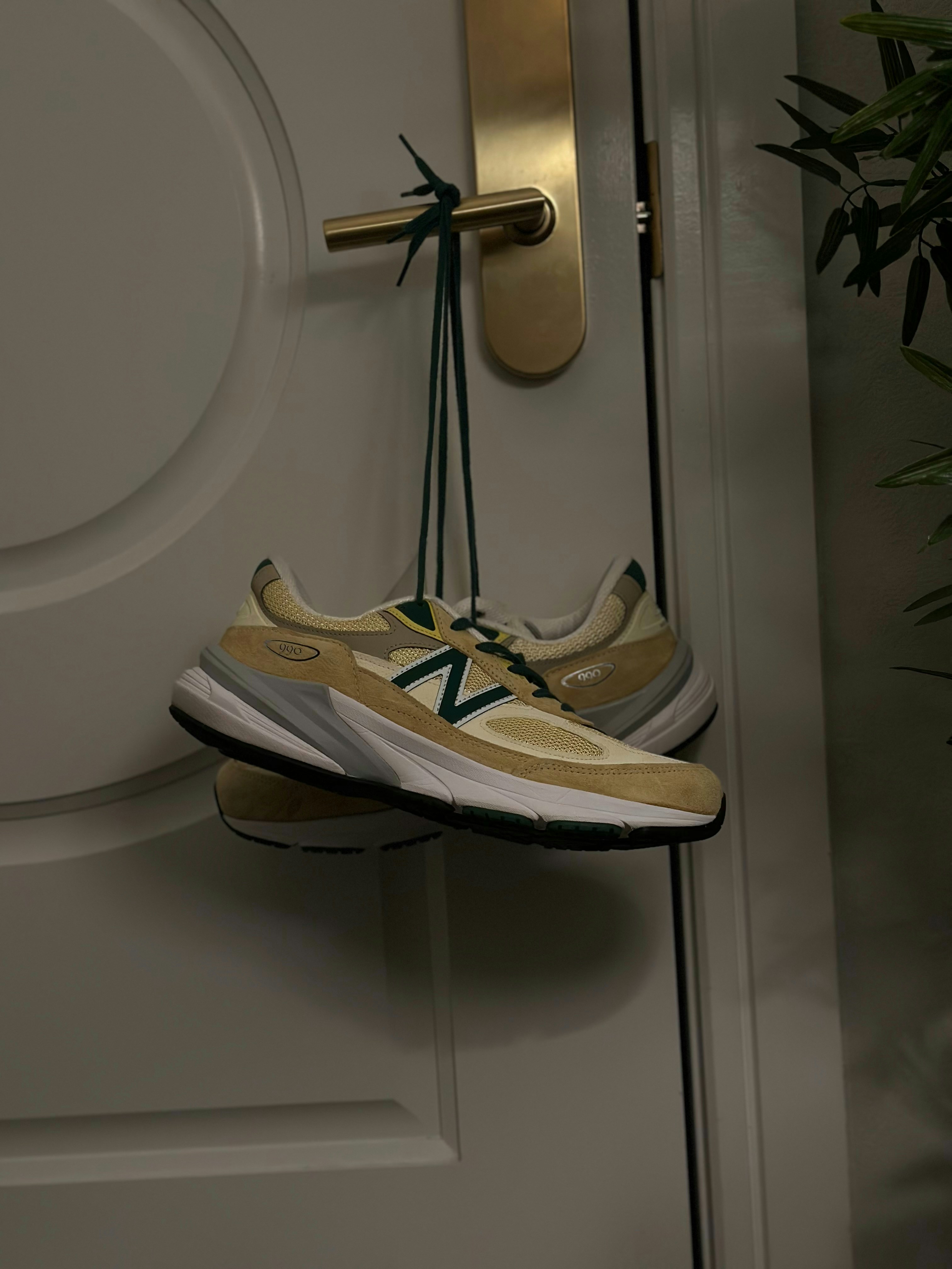 A pair of new balance shoes hanging on a door photo – Free Sneakers ...