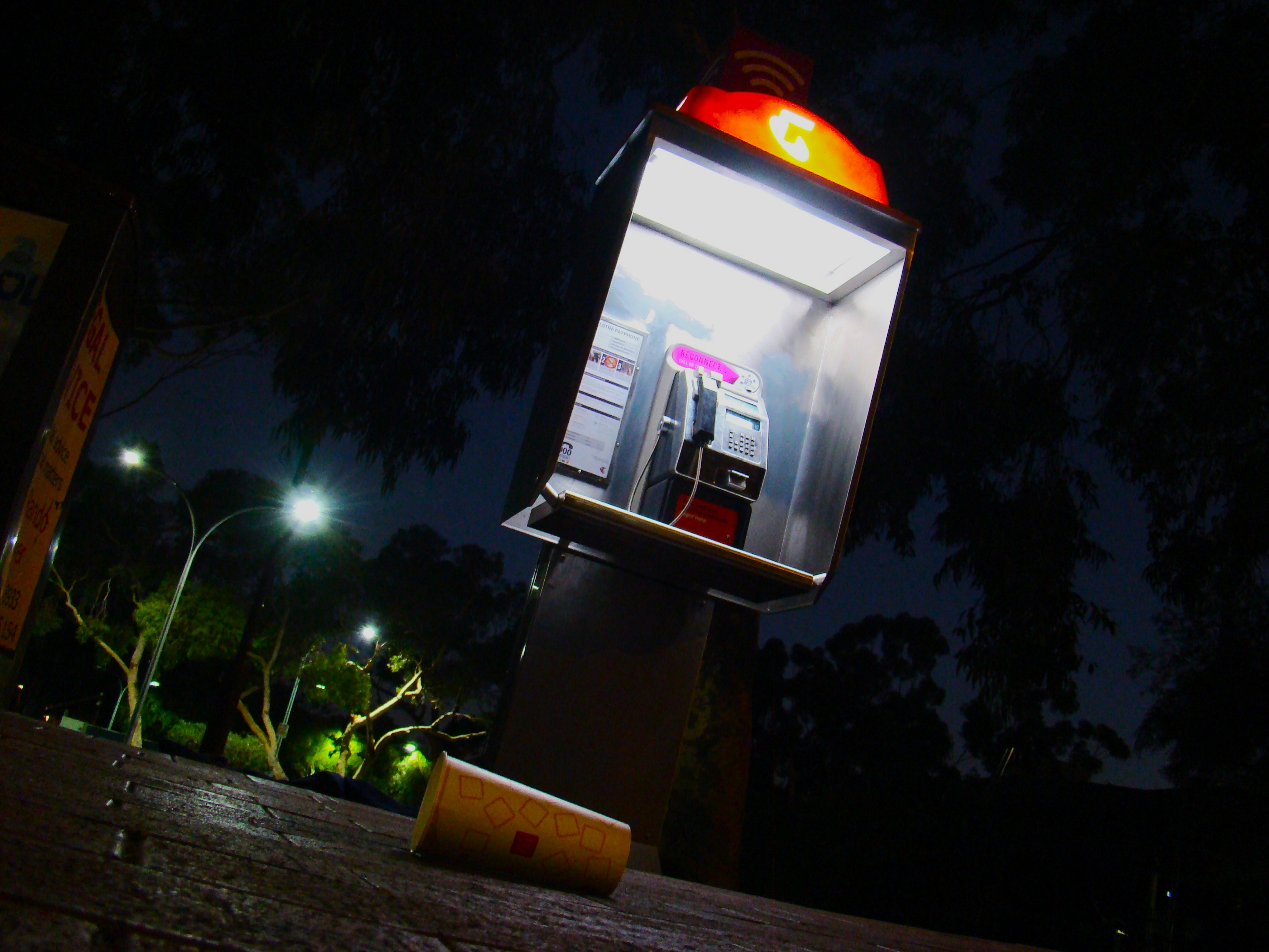 Red Beacon at Night: A Neon Public Booth in a Quiet Park