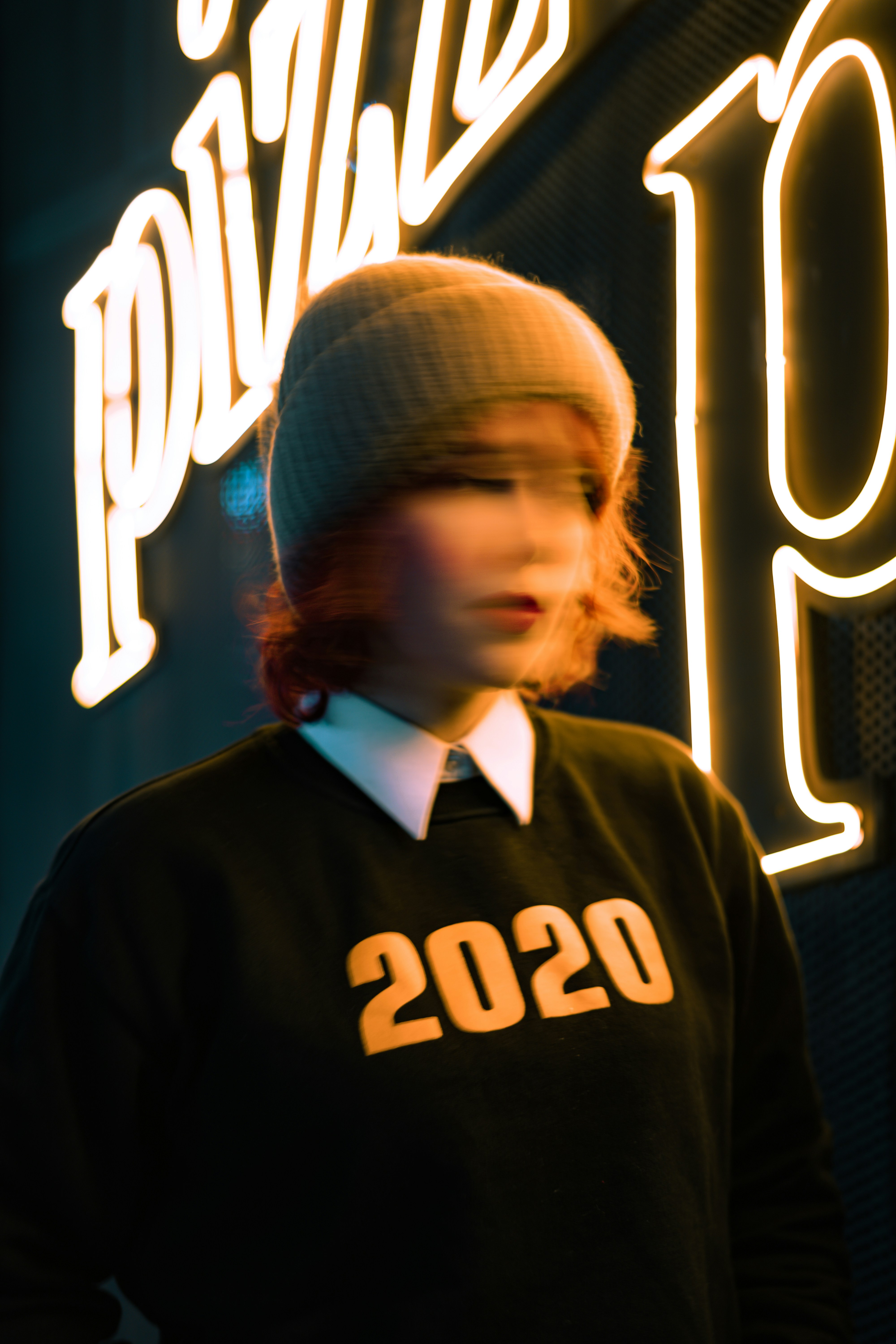 Neon Portrait in Slow Motion: A 2020 Sweatshirt Under Glowing Signage