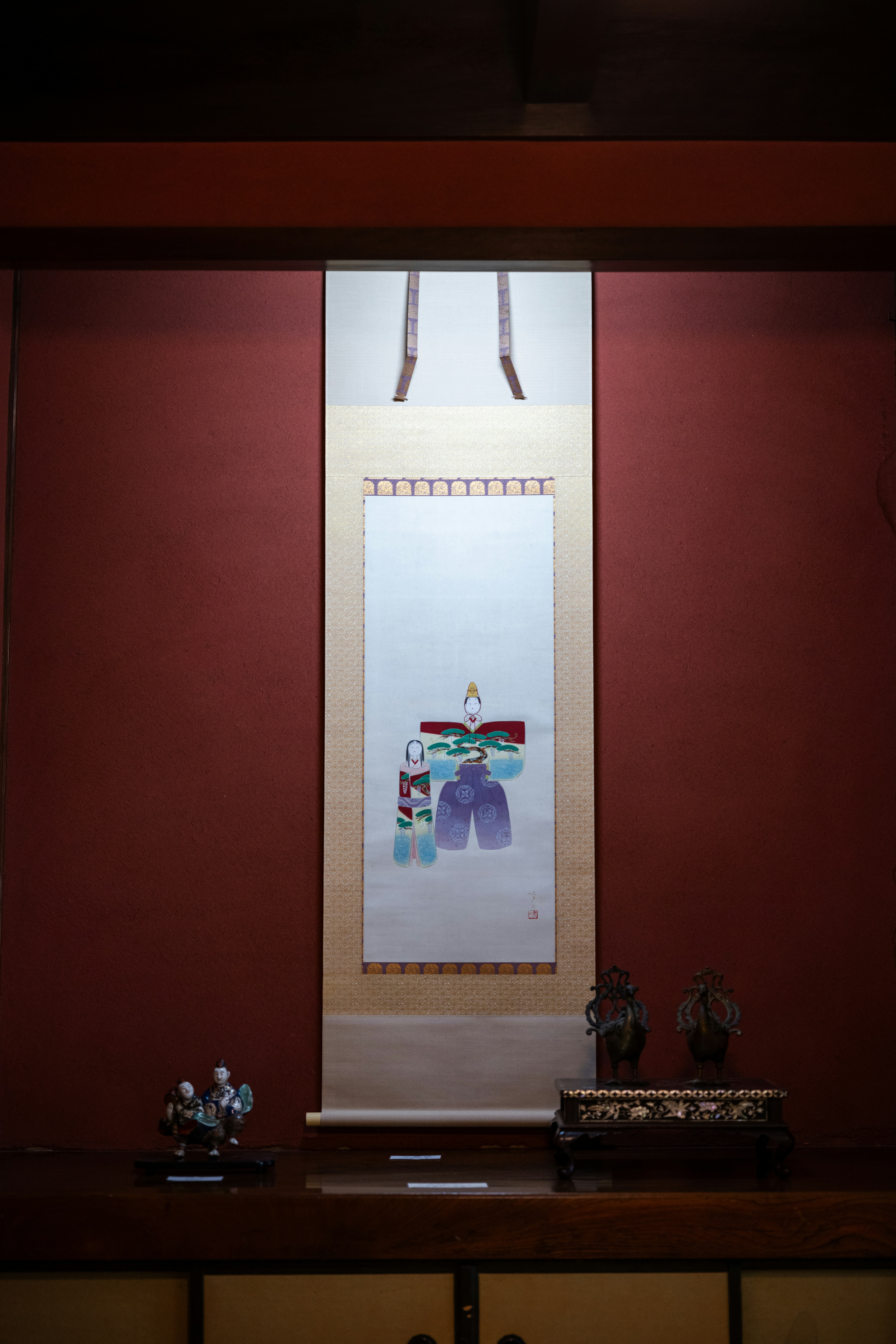 Centered Silk Scroll Amid Crimson Walls: A Quiet Gallery Moment