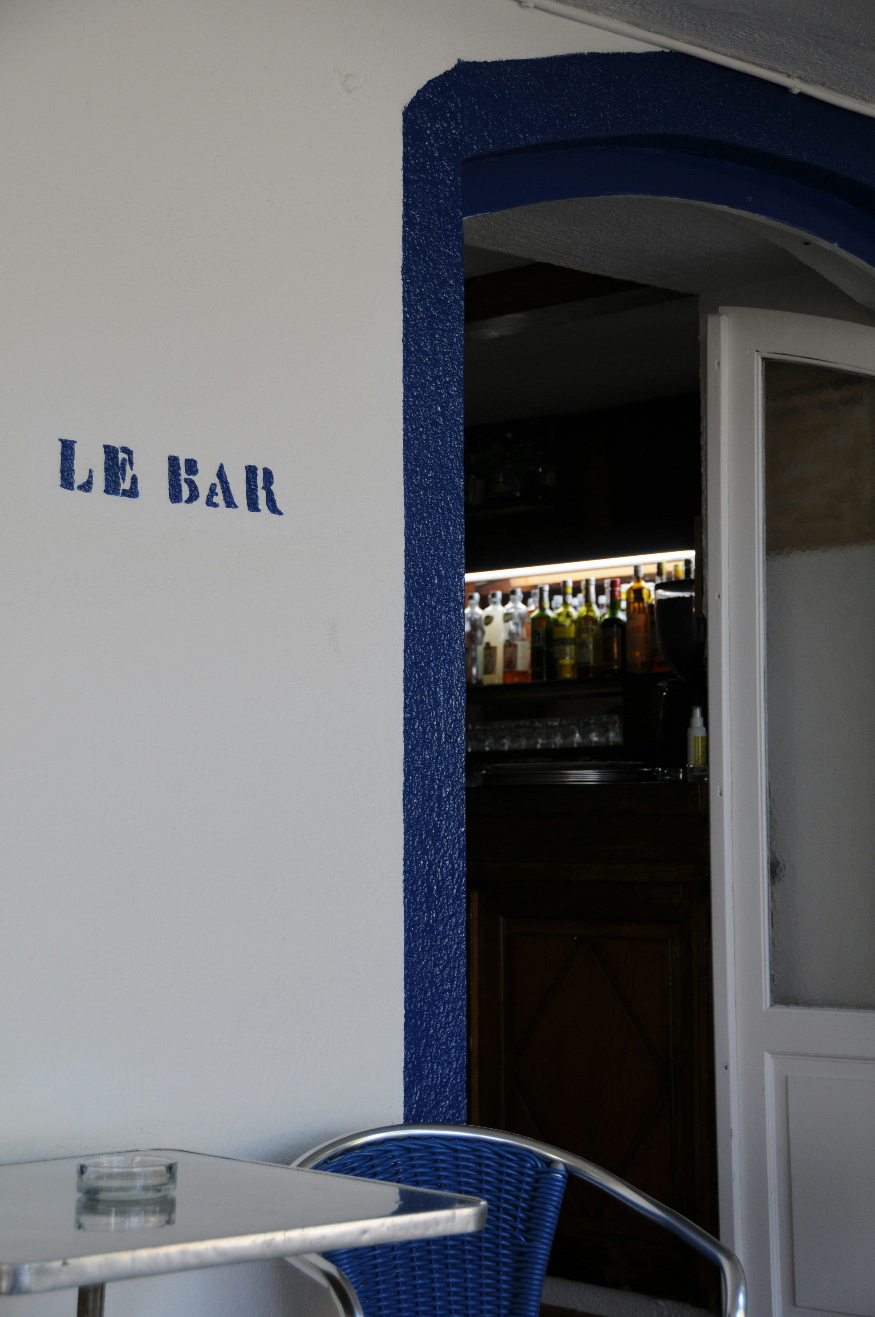 Blue Archway Framing a Warm Bar Interior with Bottles on Display