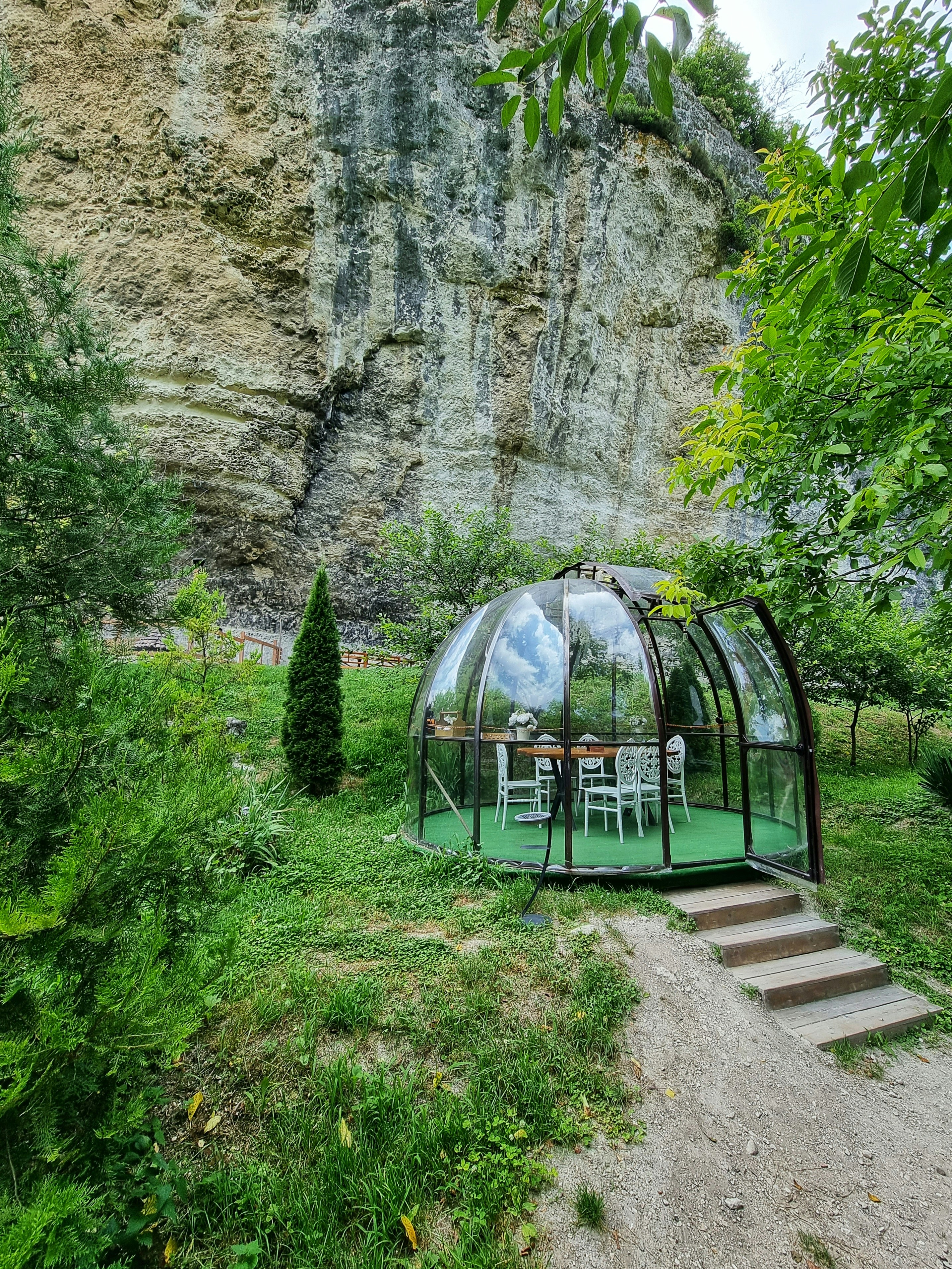 Glass-Domed Oasis Nestled Beside a Limestone Cliff