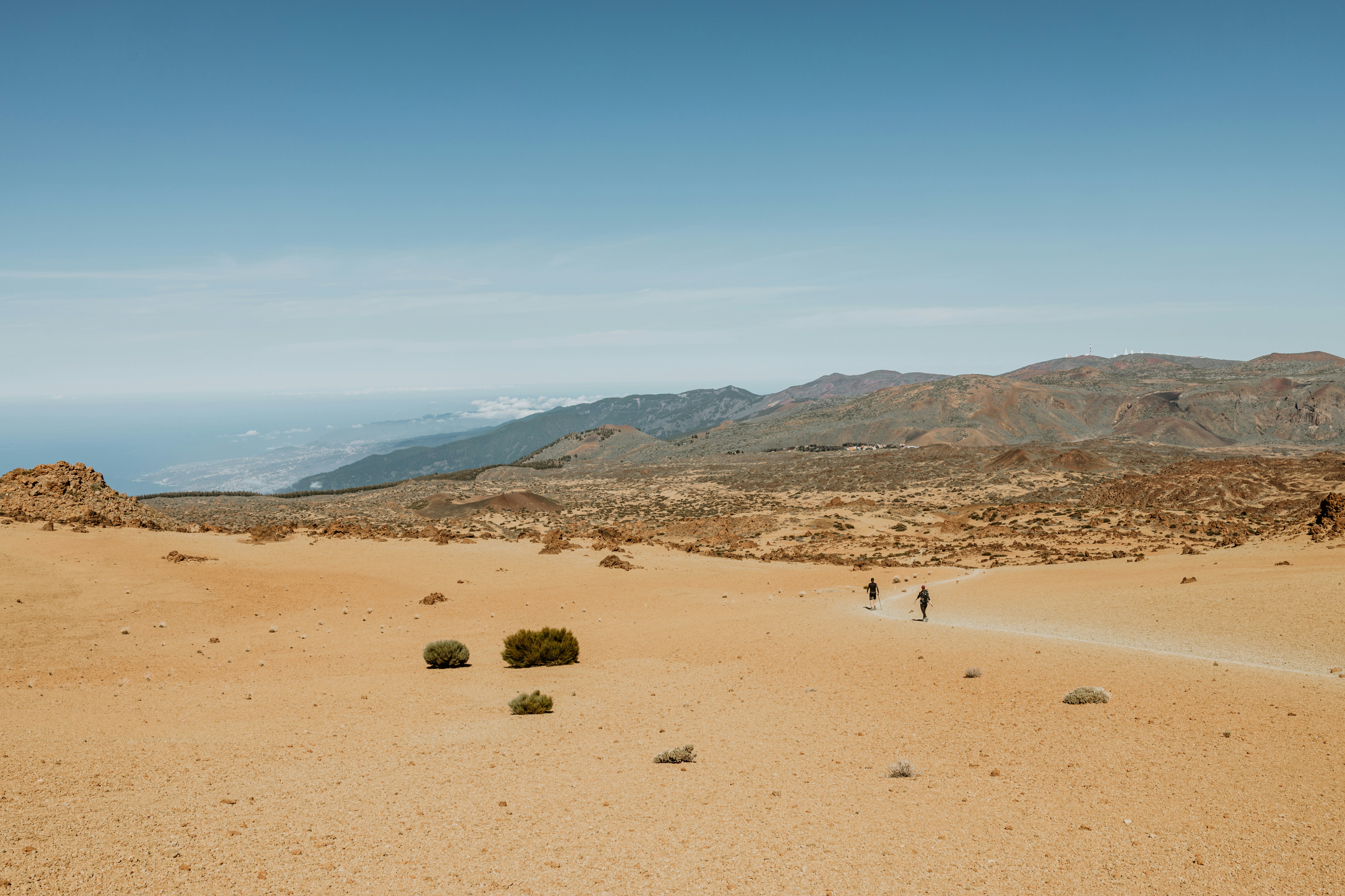 Rim Walkers on a Citrine Plain: Two Hikers Tread the Desert Rim