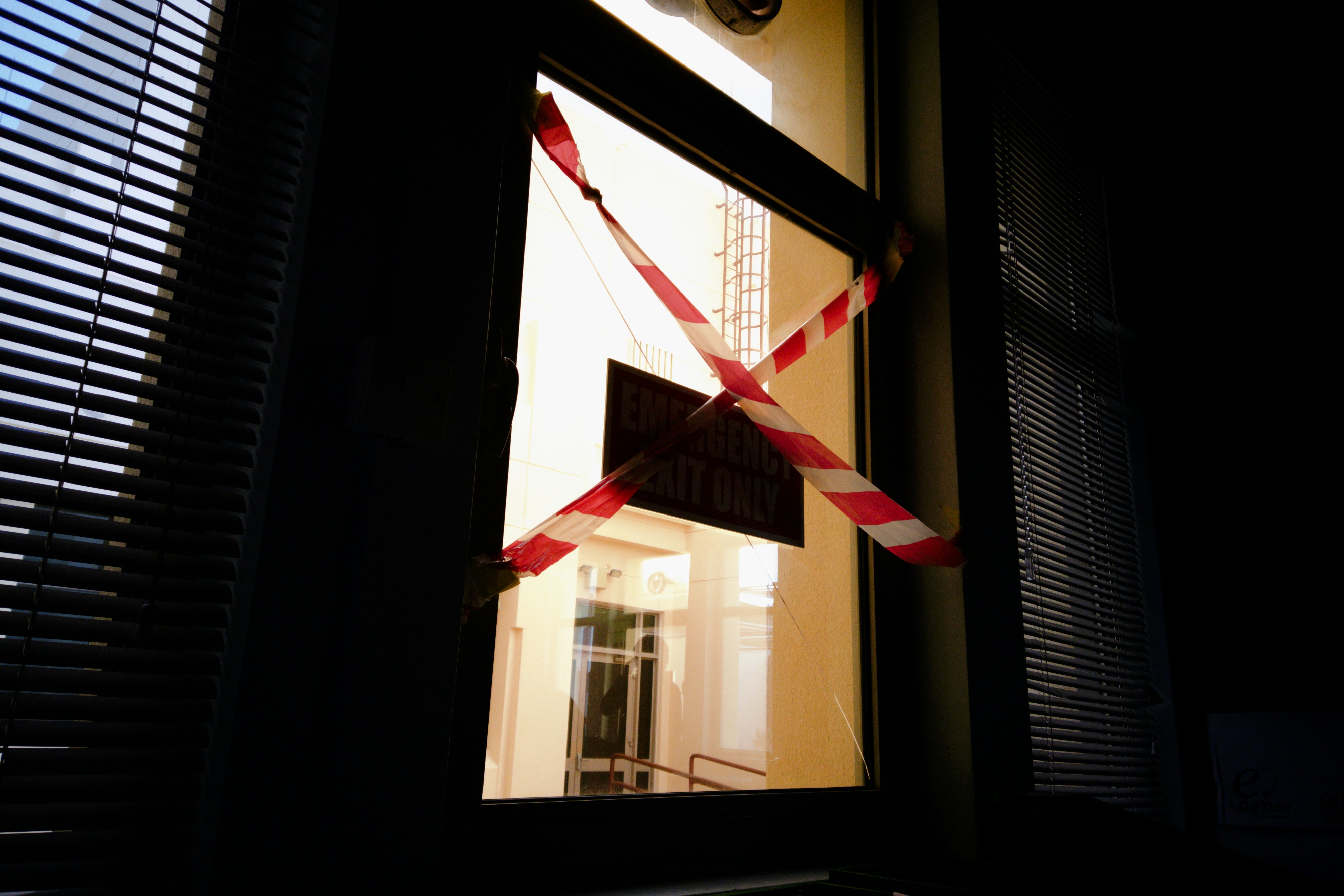 A red and white striped caution sign in front of a window photo – Free ...