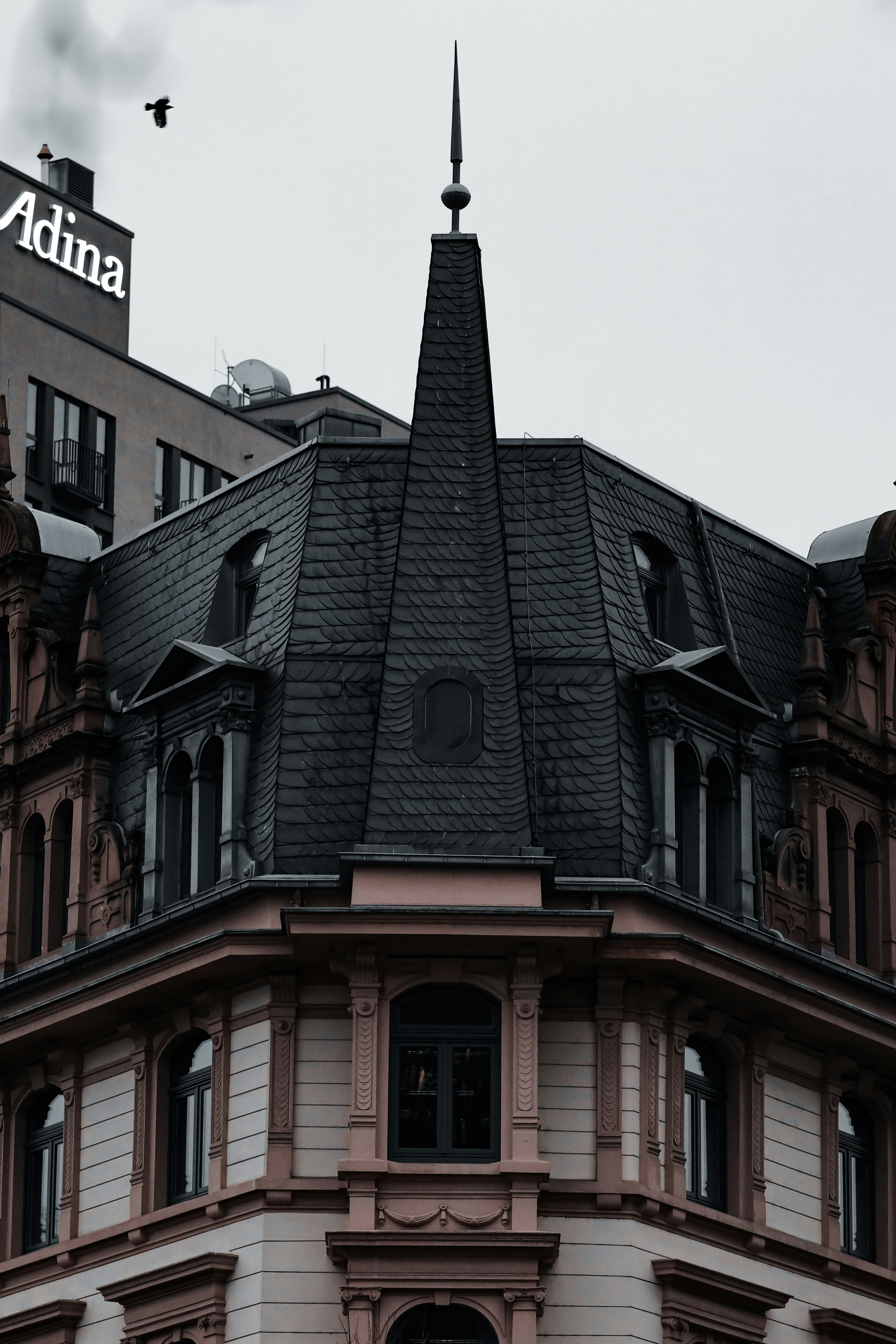 Slate Spire Above Pink Facades: A City Rooftop Portrait