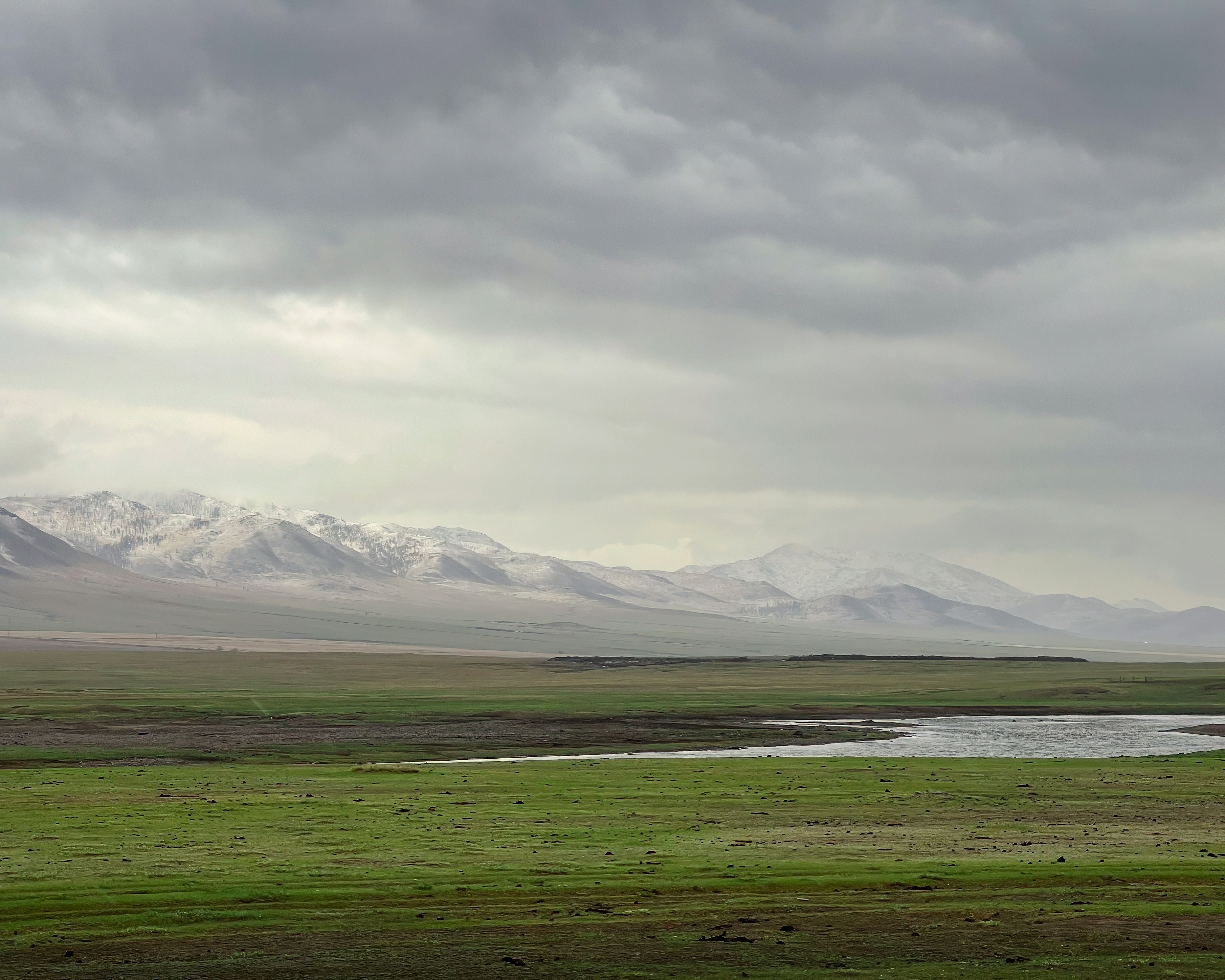 Snow-Kissed Ridge Beyond a Quiet Prairie
