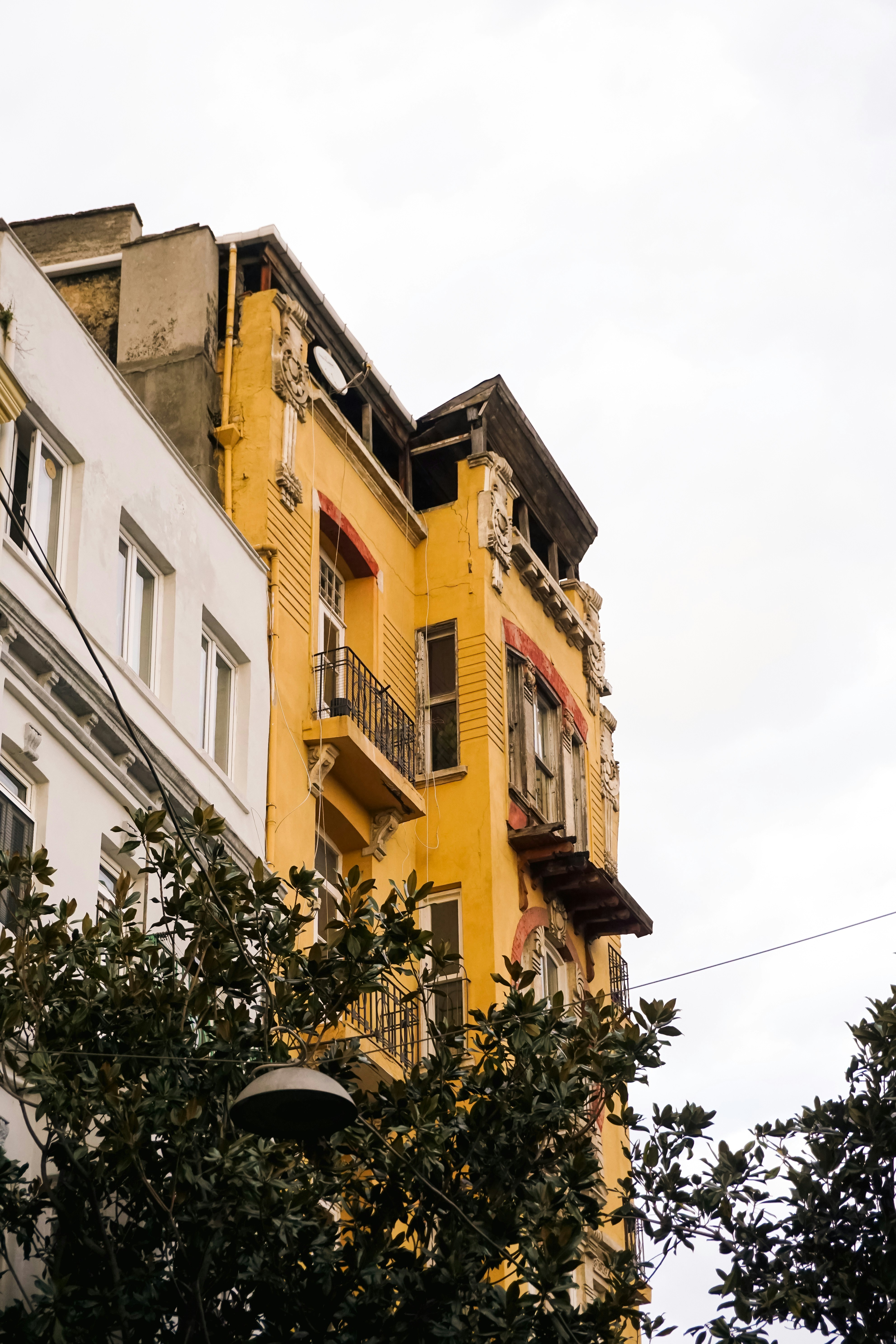 A tall yellow building with balconies and balconies photo – Free ...