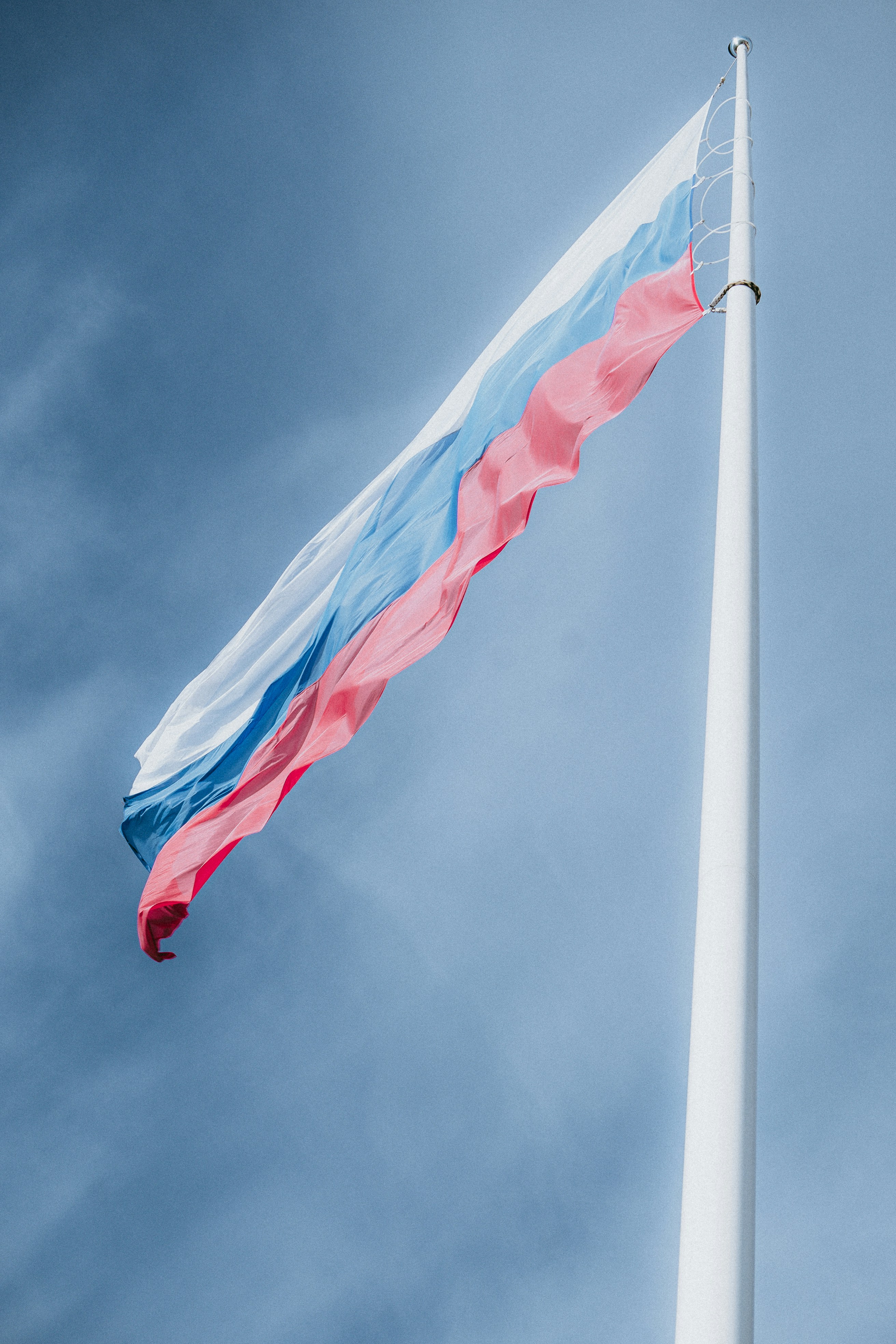 Diagonal Tricolor in a Wind-Worn Arc Above a Quiet Blue Sky