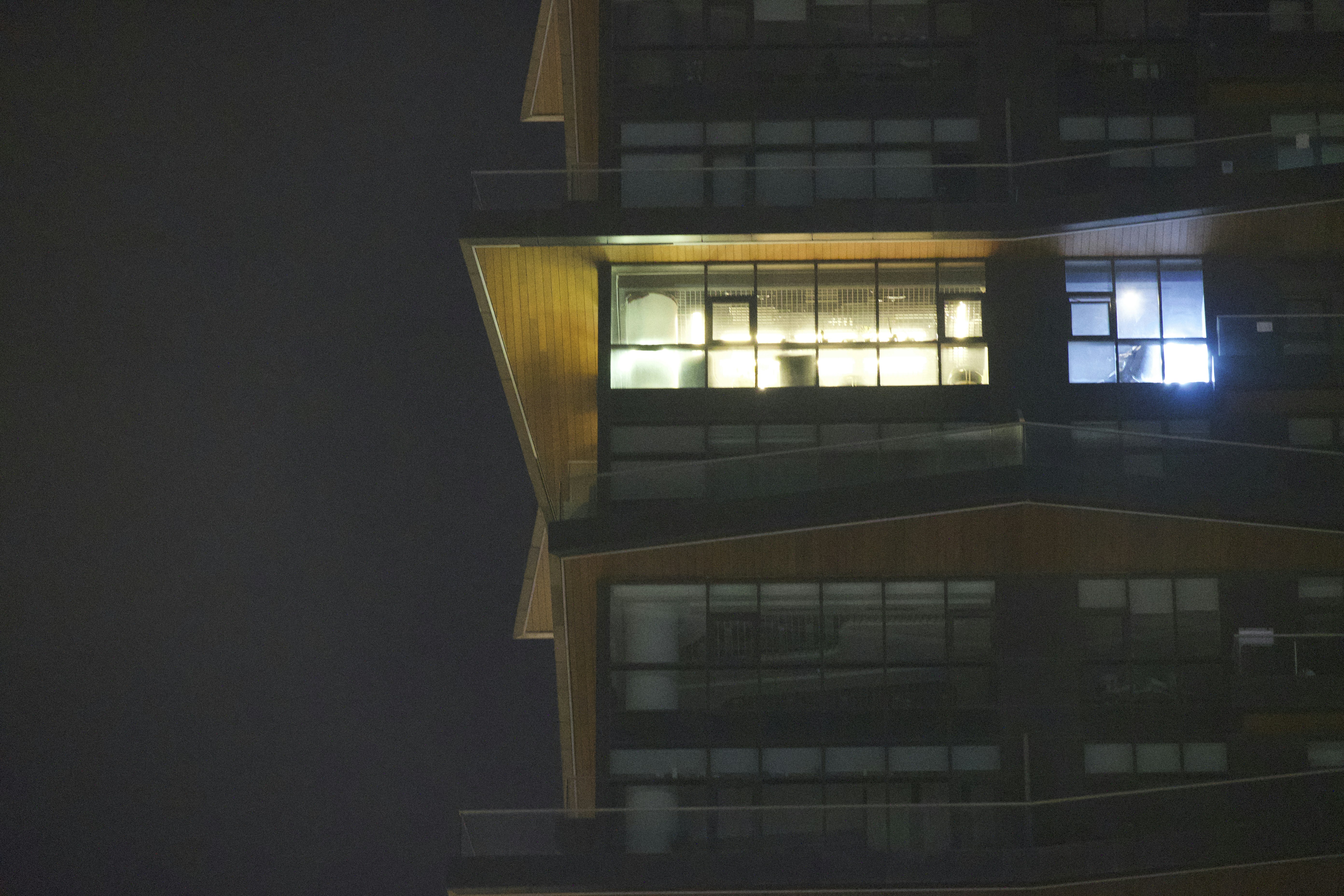 A tall building with windows lit up at night photo – Free Building ...
