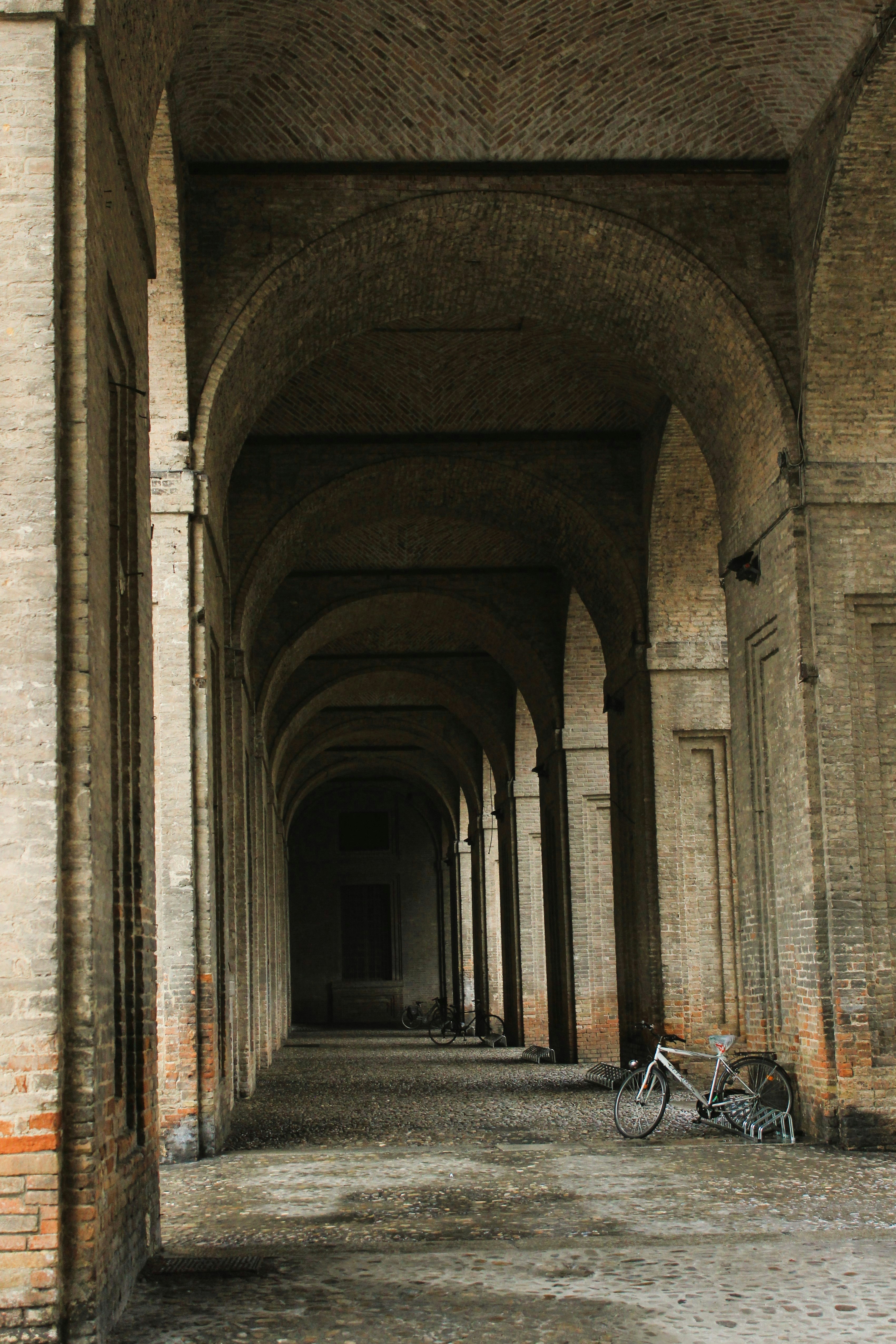 Echoes Beneath Brick Arches: A Quiet Corridor and a Bicycle