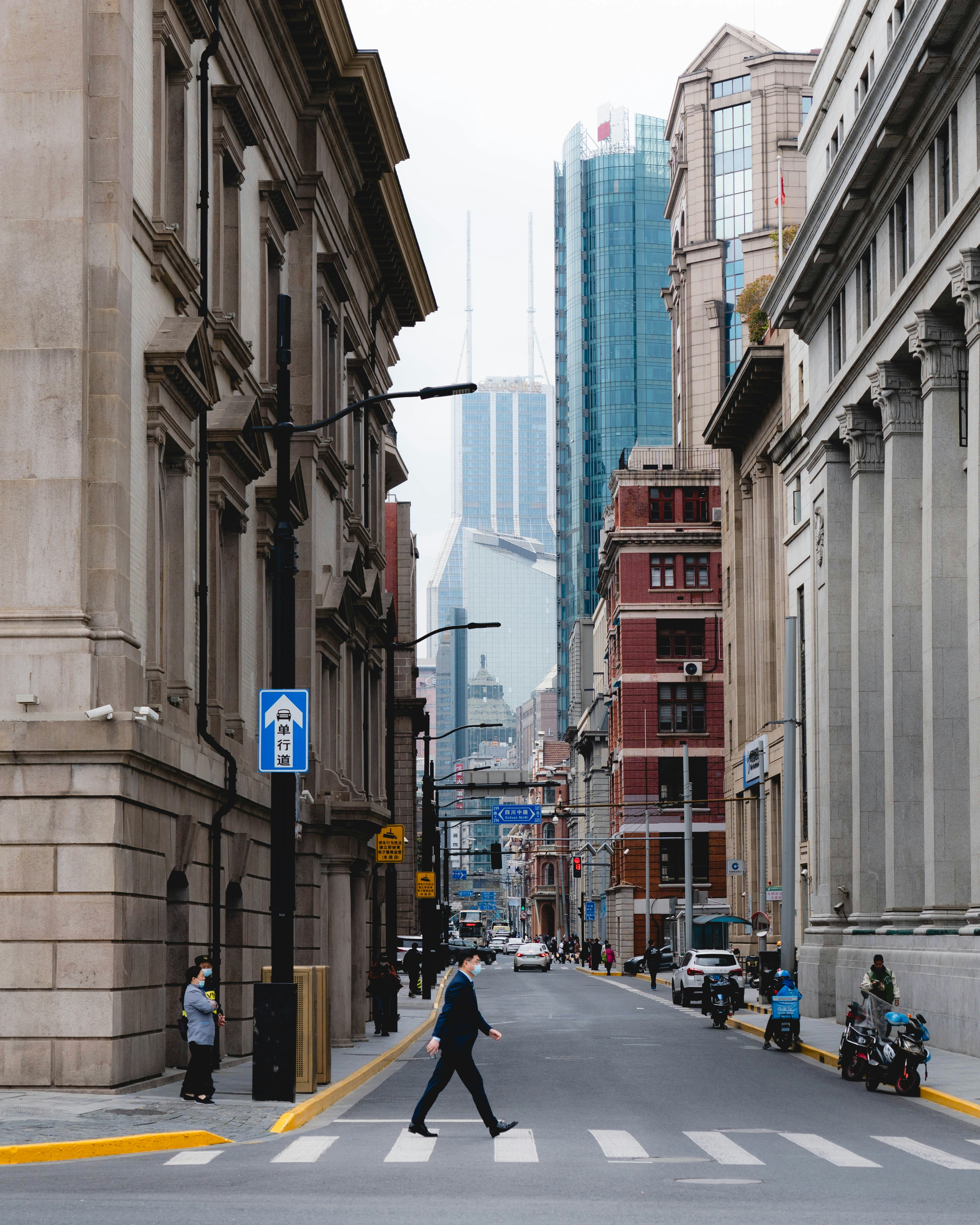 City Crossing: A Pedestrian Walks Through A Canyon of Stone and Glass